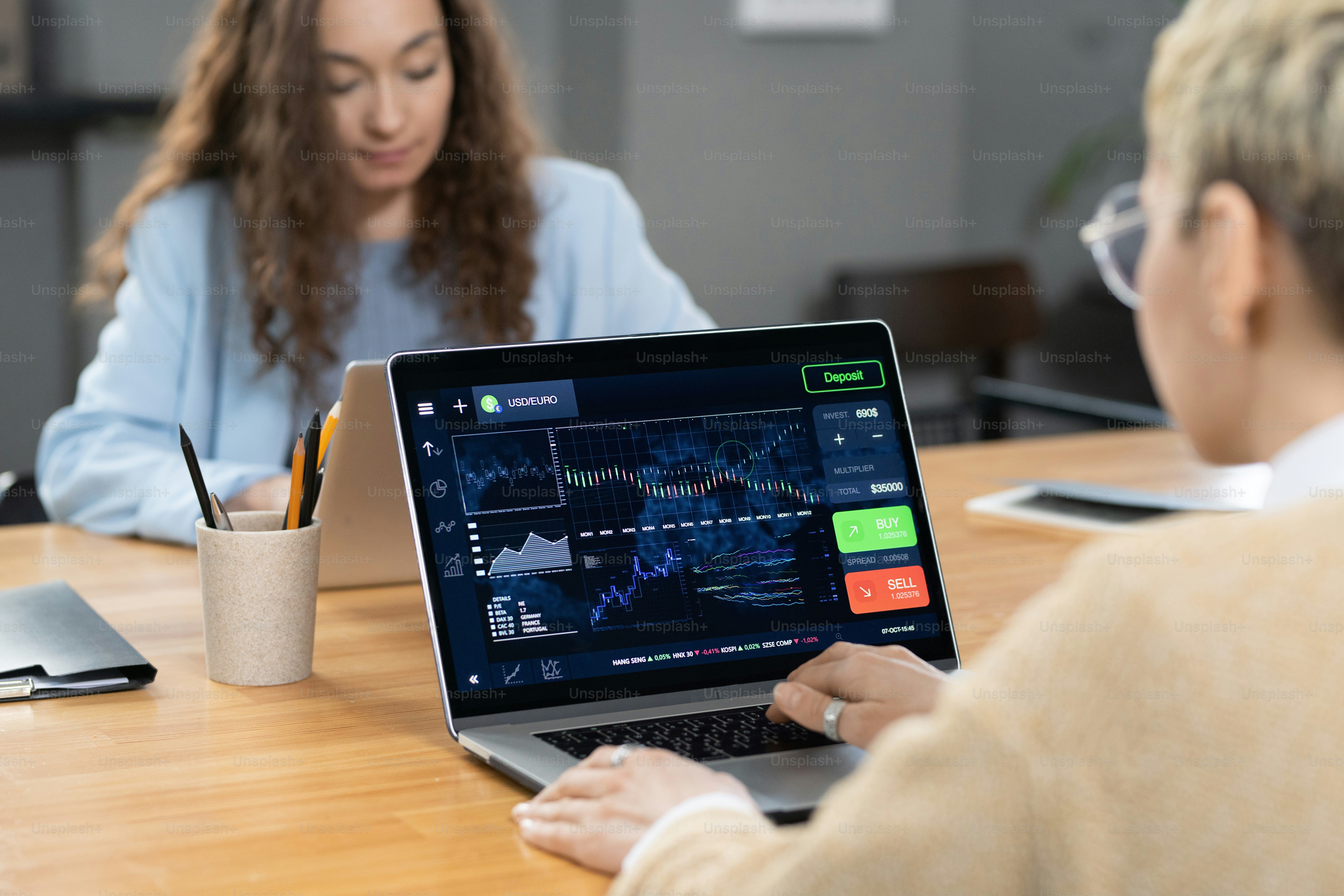 Young female financier sitting in front of laptop with financial data ...