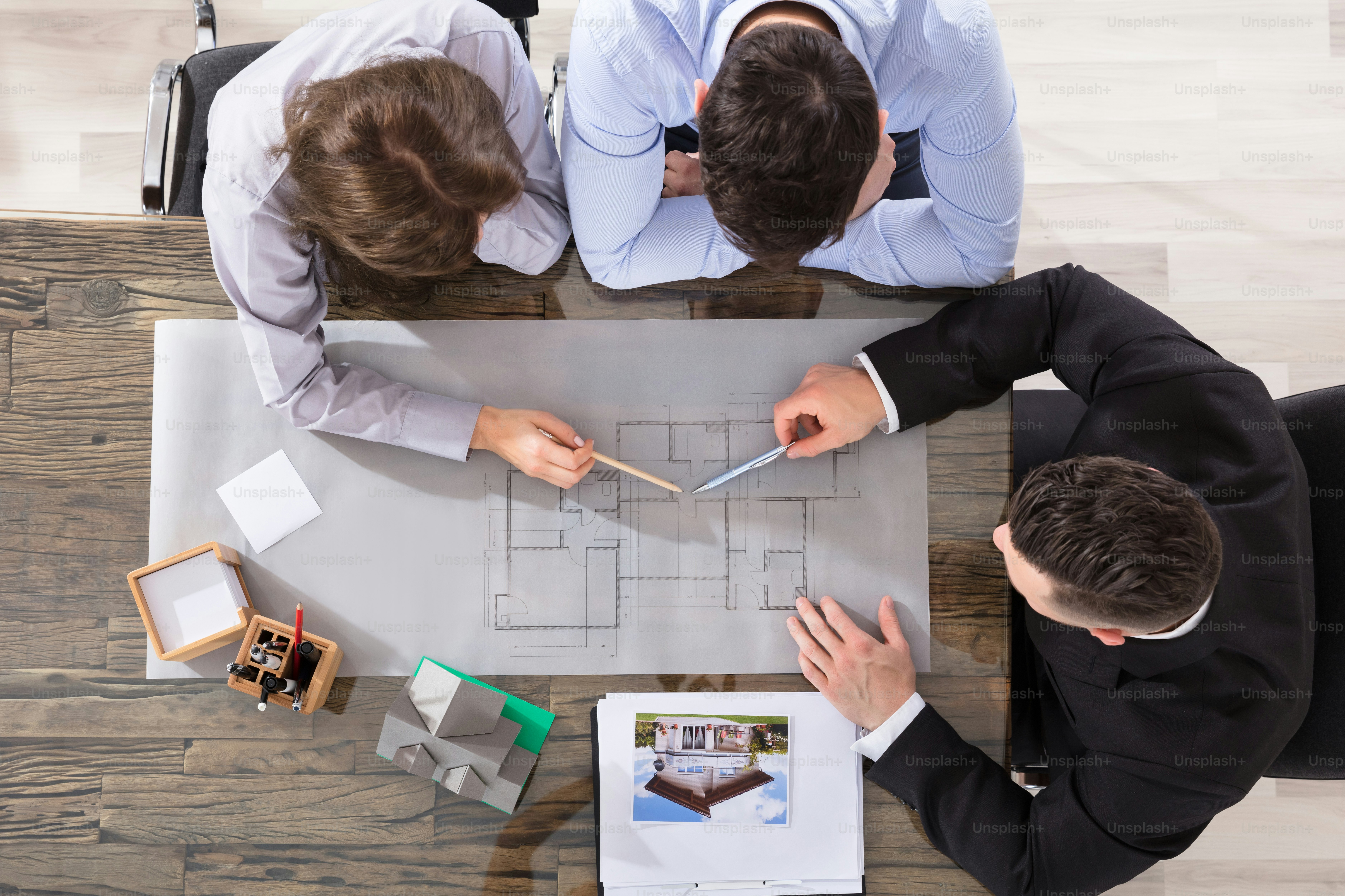 Elevated View Of Architect Working On Blueprint With Couple photo ...