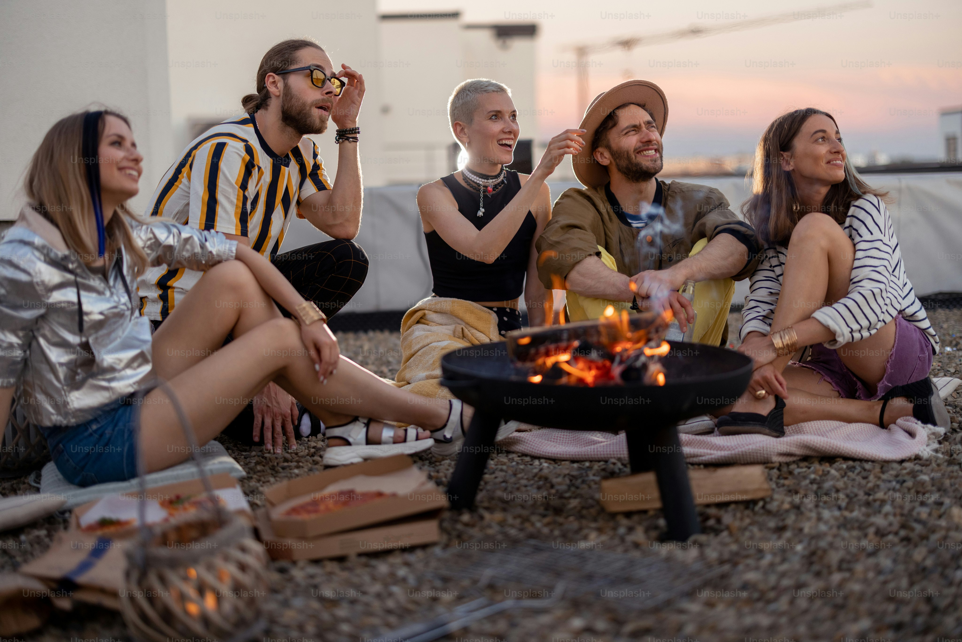Group of young stylish friends sitting together by the fireplace ...