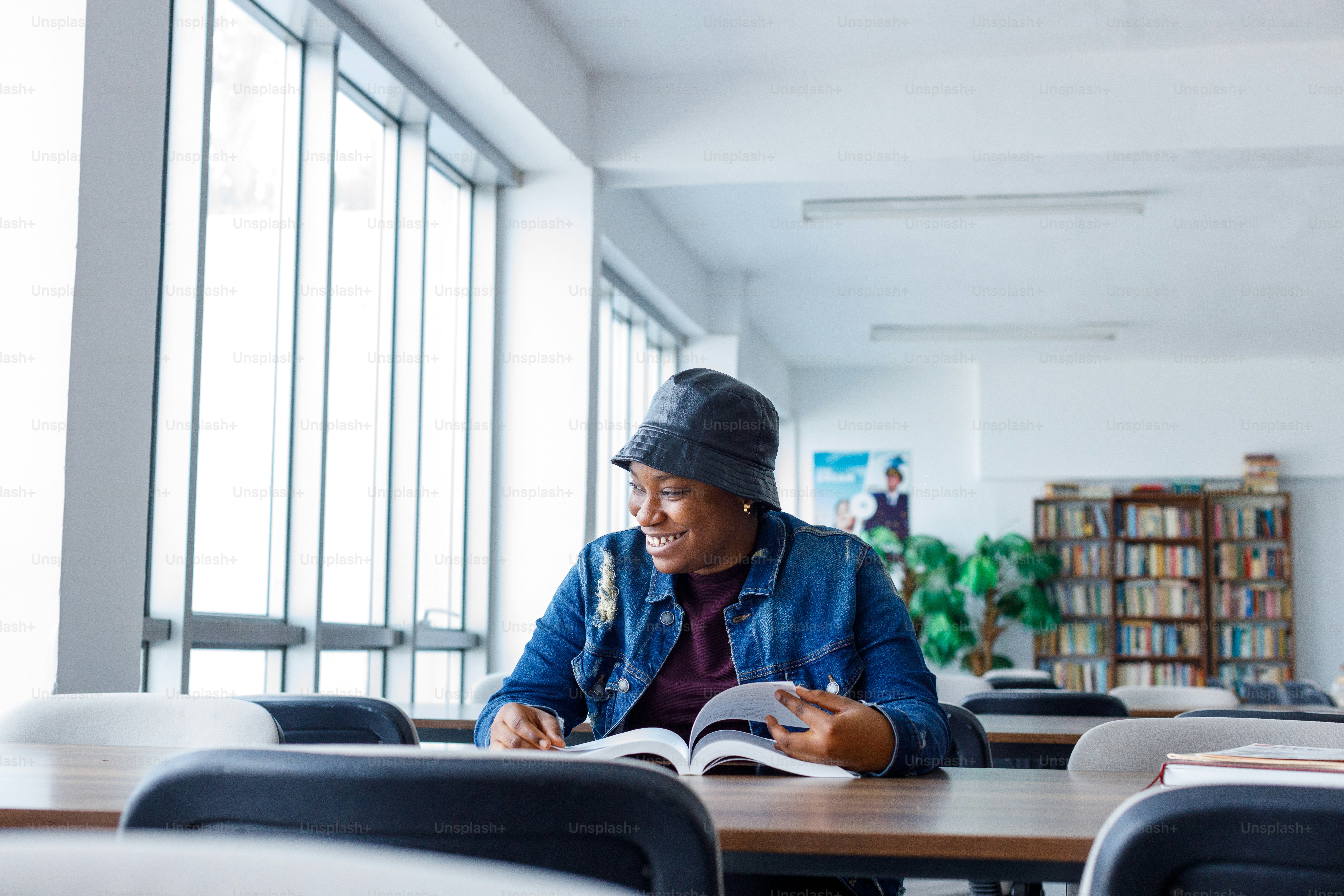 A person sitting at a table reading a book photo – Students Image on ...