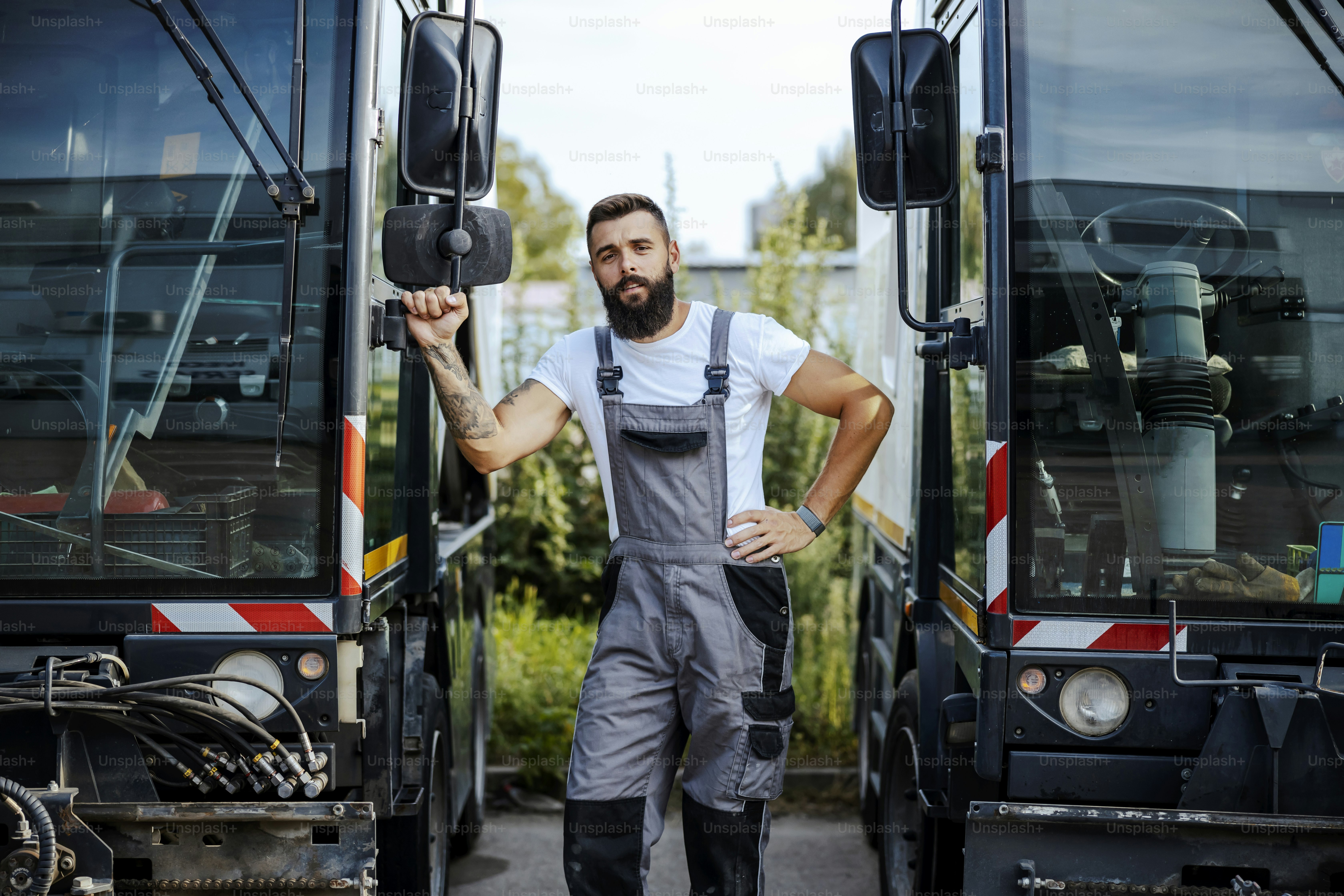 A hardworking auto-mechanic standing outdoors and leaning on the bus ...