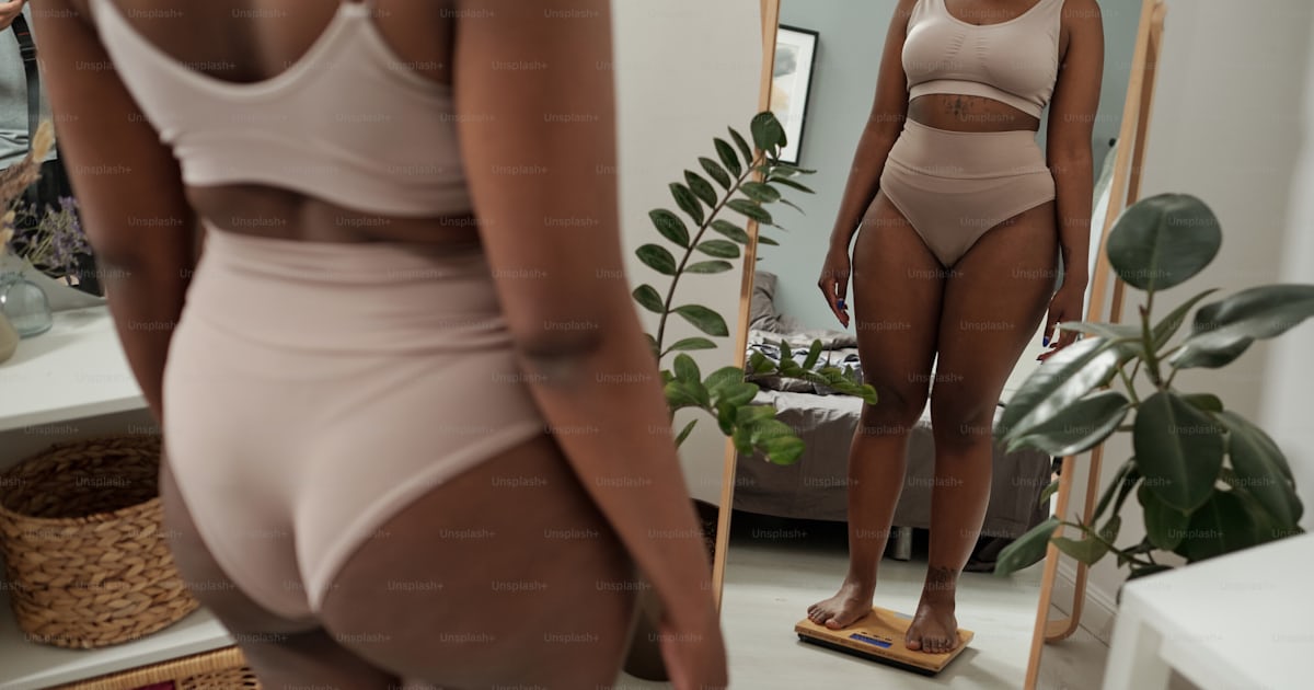 속옷을 입은 플러스 사이즈 여성이 큰 거울 앞에서 체중계로 체중을 확인한다 사진 Unsplash의 속옷 이미지
