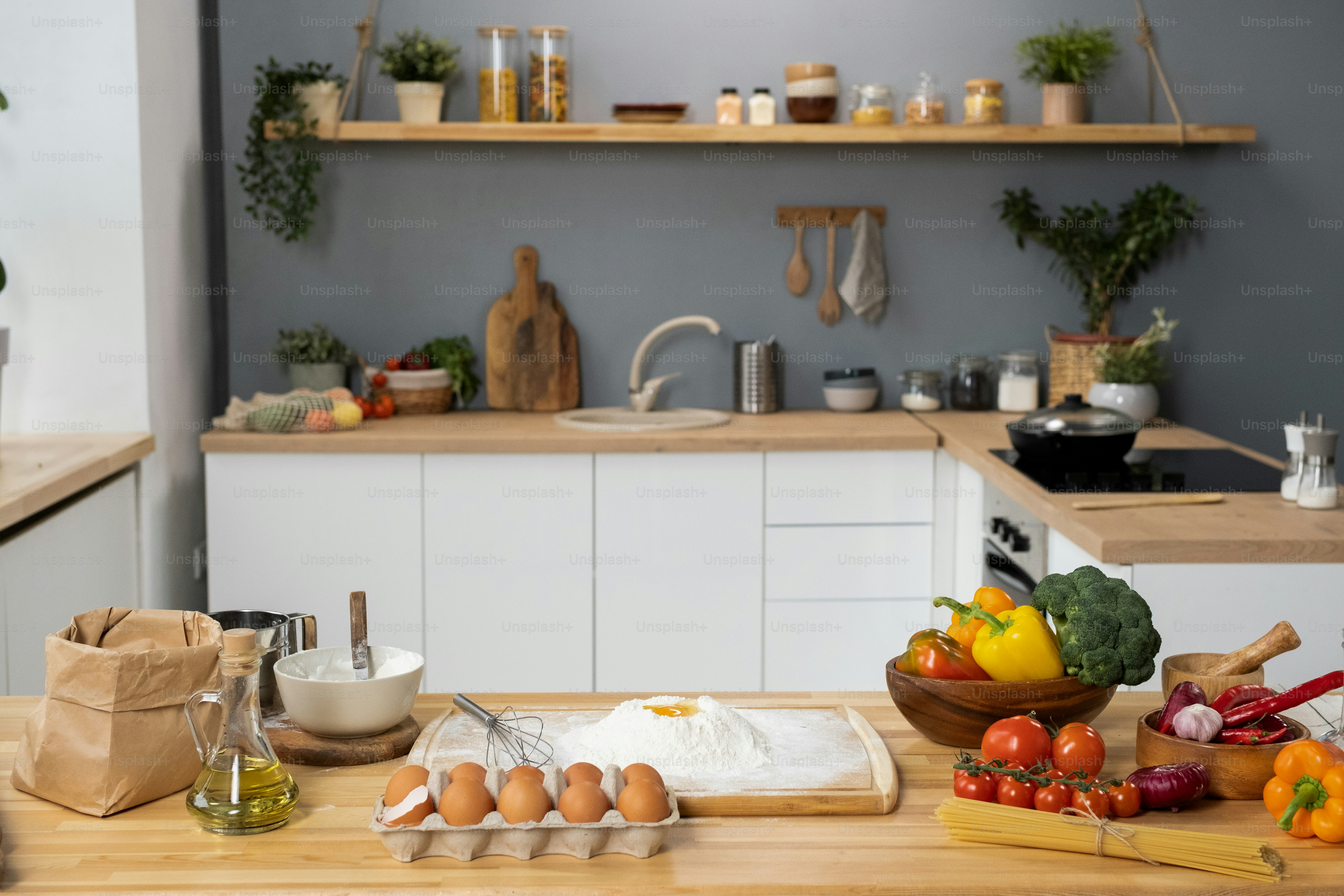 Interior of kitchen with wooden table, fresh vegetables, sifted flour ...