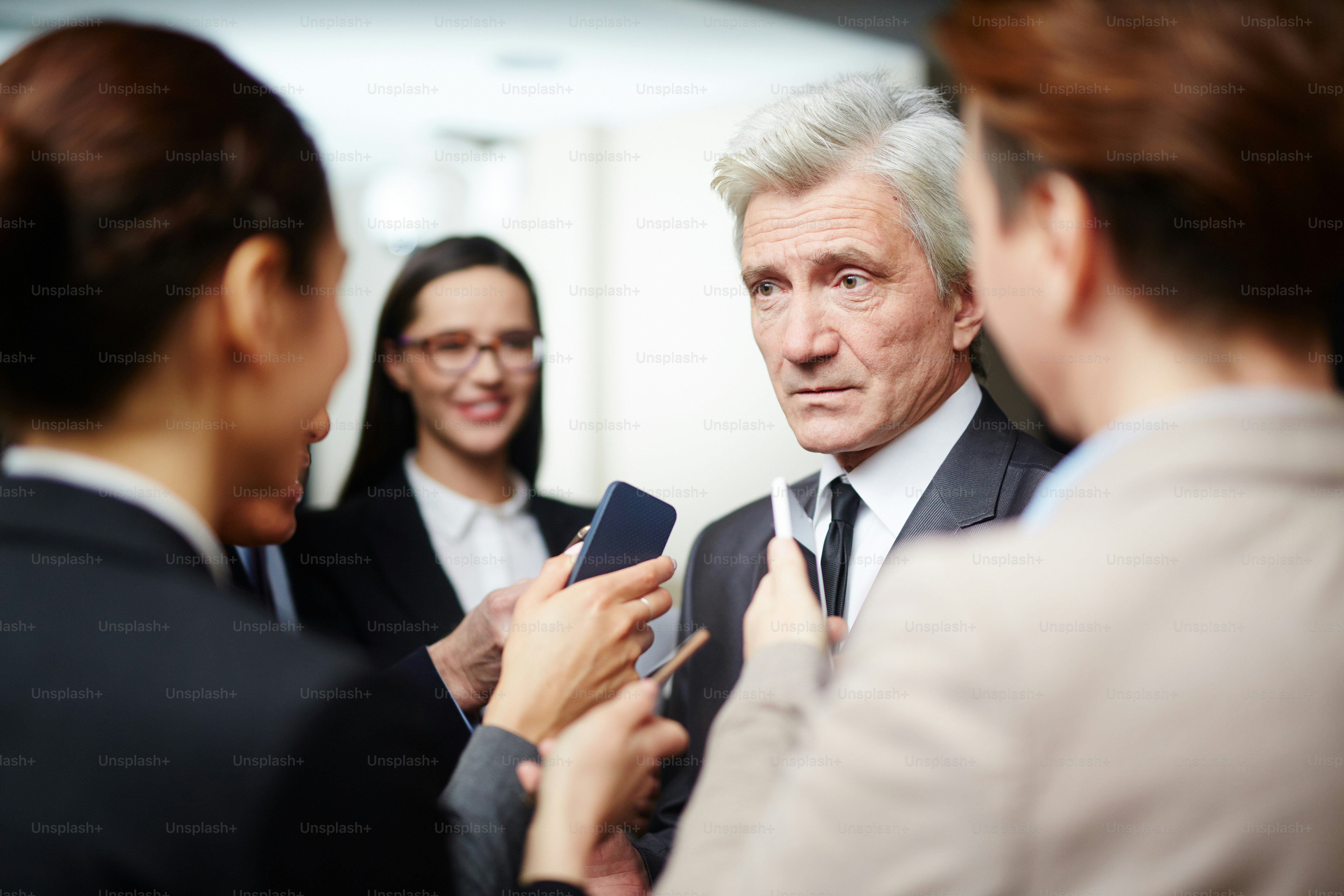Confident politician in suit asking questions of journalists during ...