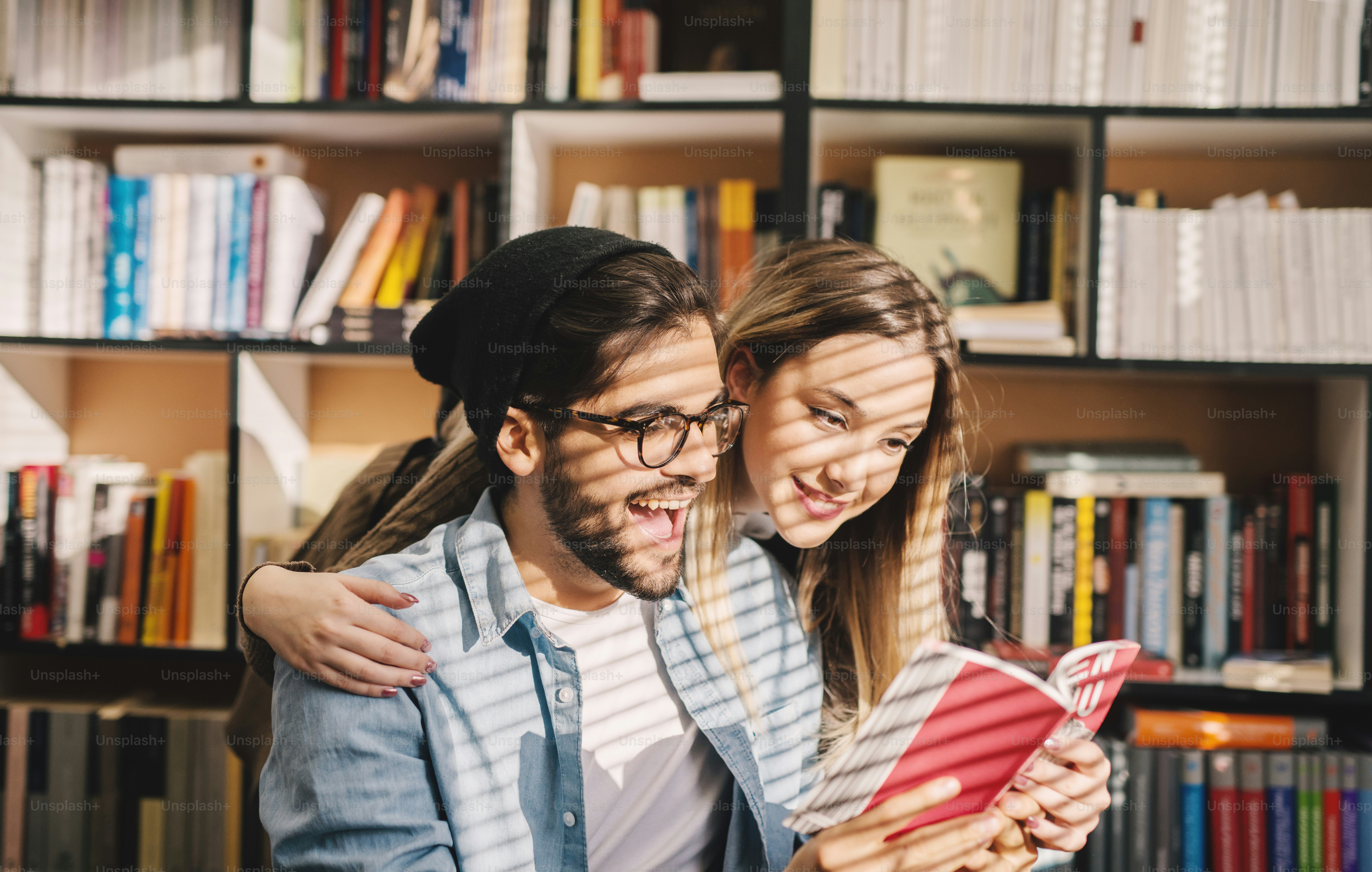 Picture of two young beautiful openminded students reading a book ...