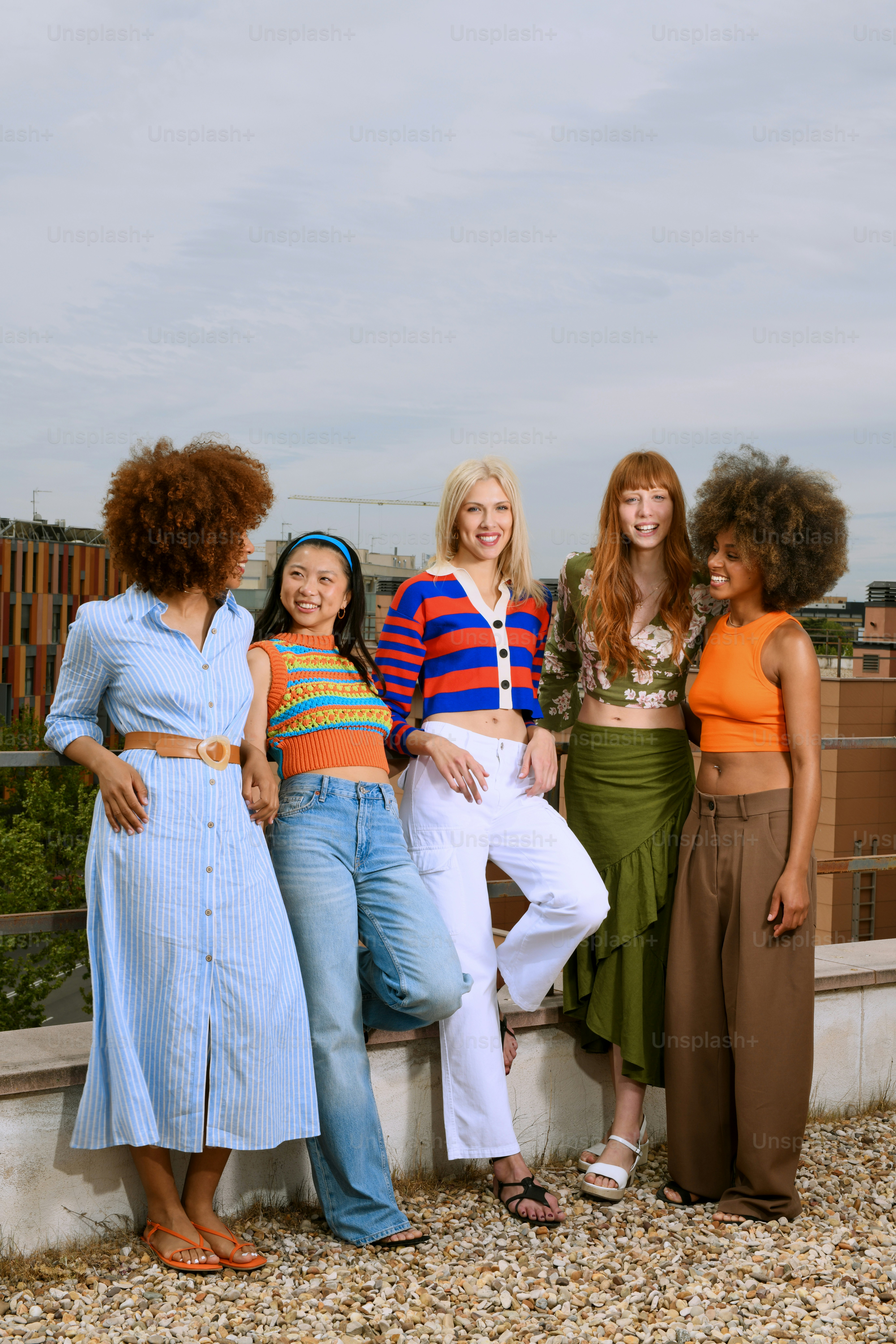 A group of women sitting on top of a yellow and white checkered blanket ...
