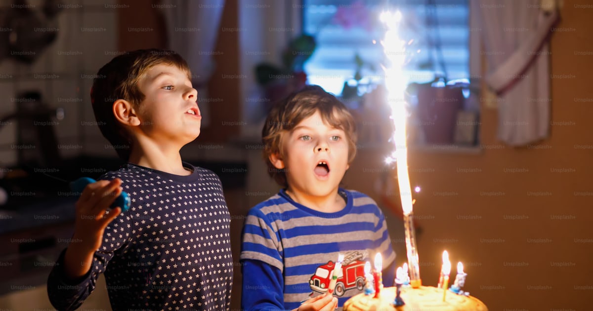 두 명의 아름다운 아이들 생일을 축하하고 집에서 만든 구운 케이크에 촛불을 불고 있는 어린 미취학 소년들 형제 자매 아이들을