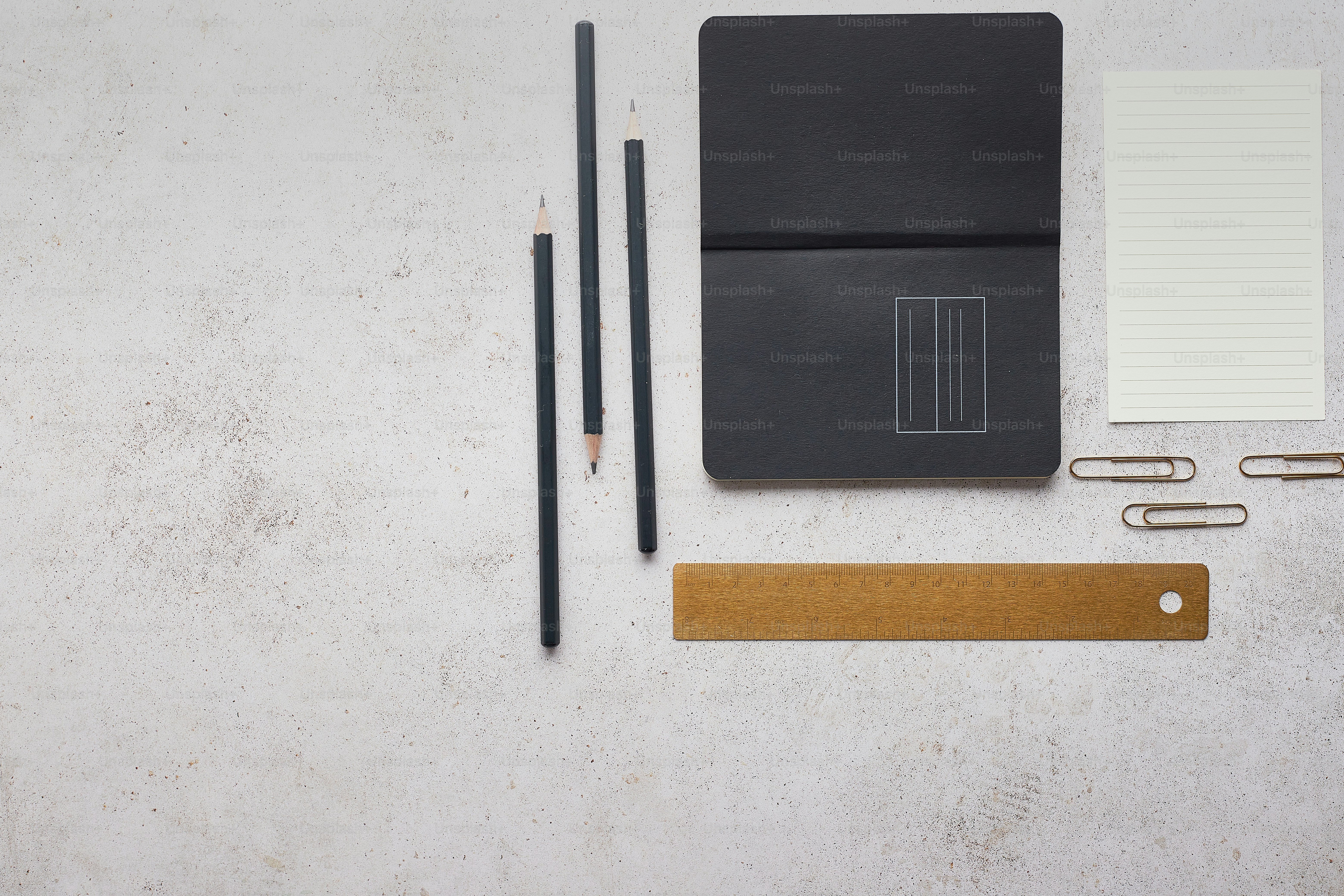 A notepad, pen, pencil, and paper clips on a table photo – Ruler Image ...