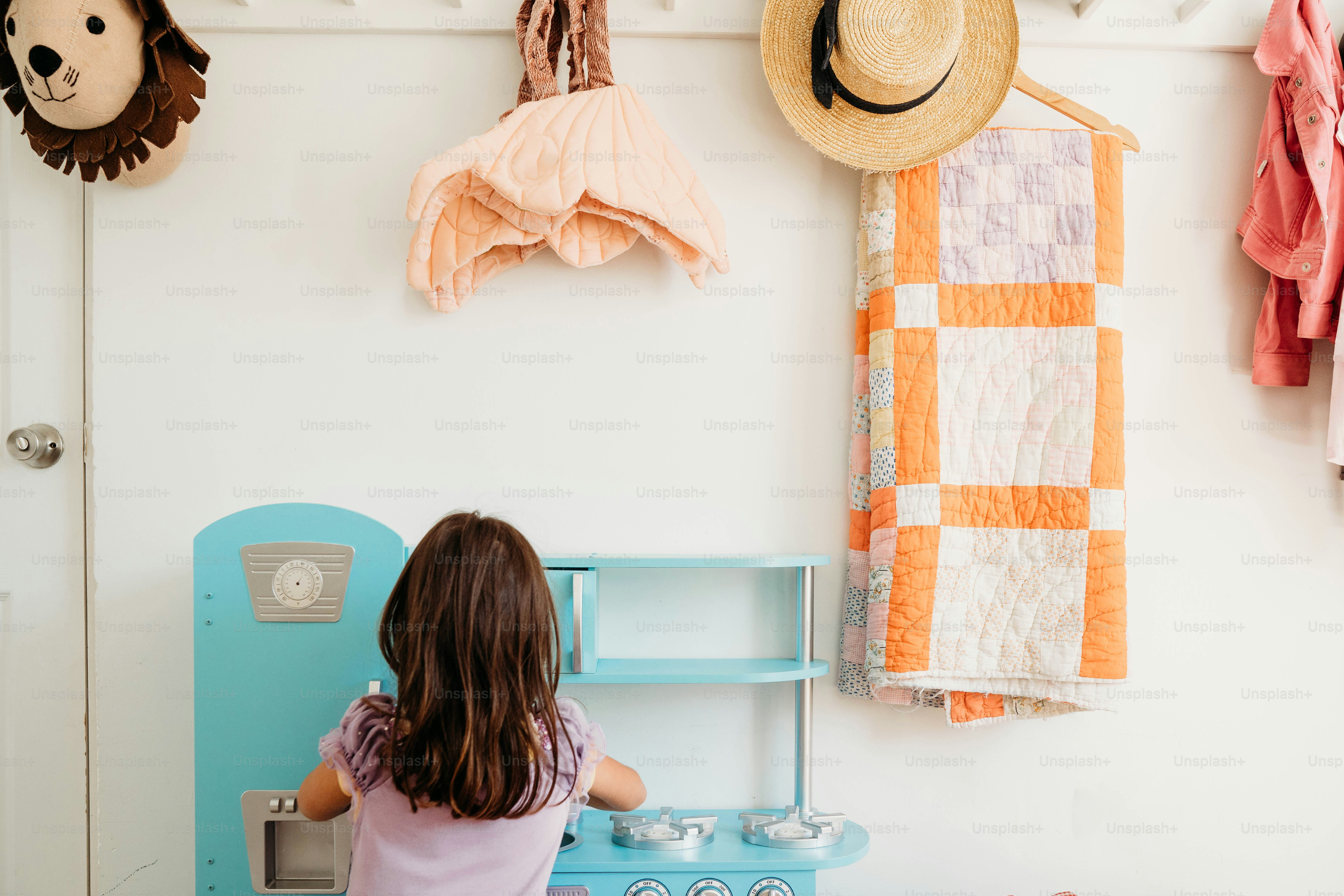 A little girl playing with a toy kitchen photo – Role play Image on ...