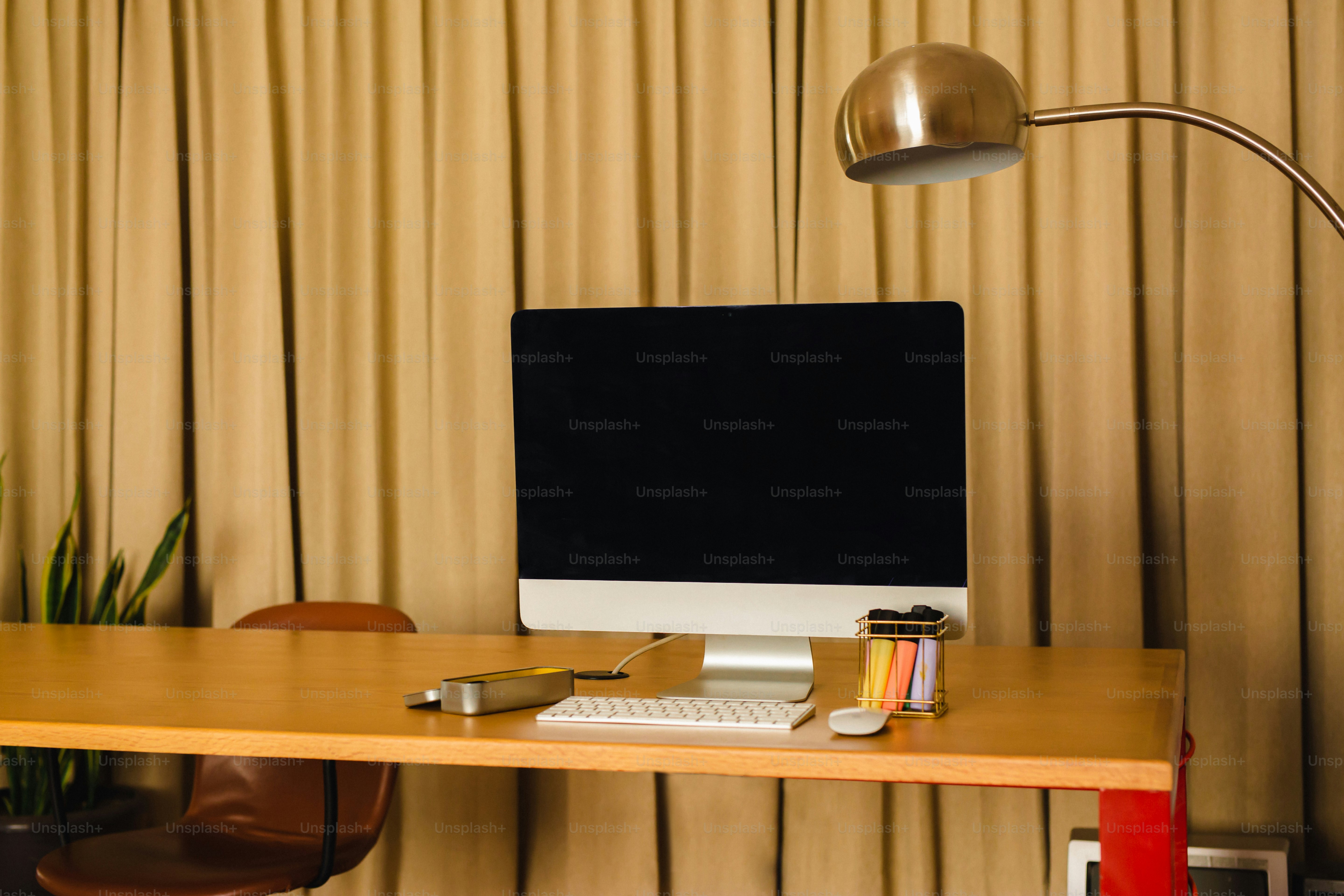 A desktop computer sitting on top of a wooden desk photo – Desk lamp ...