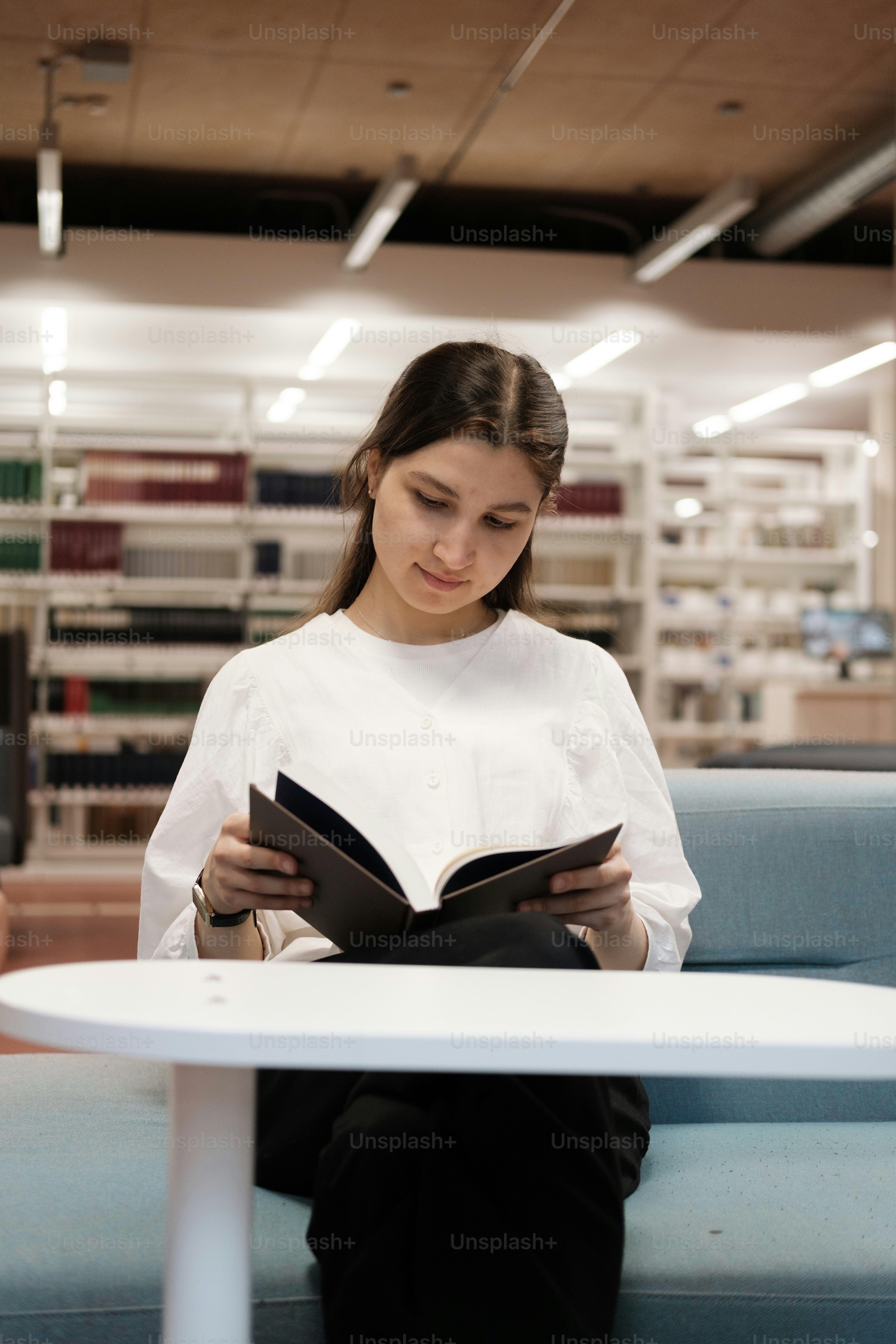 A woman reading a book in a library photo – Learn Image on Unsplash