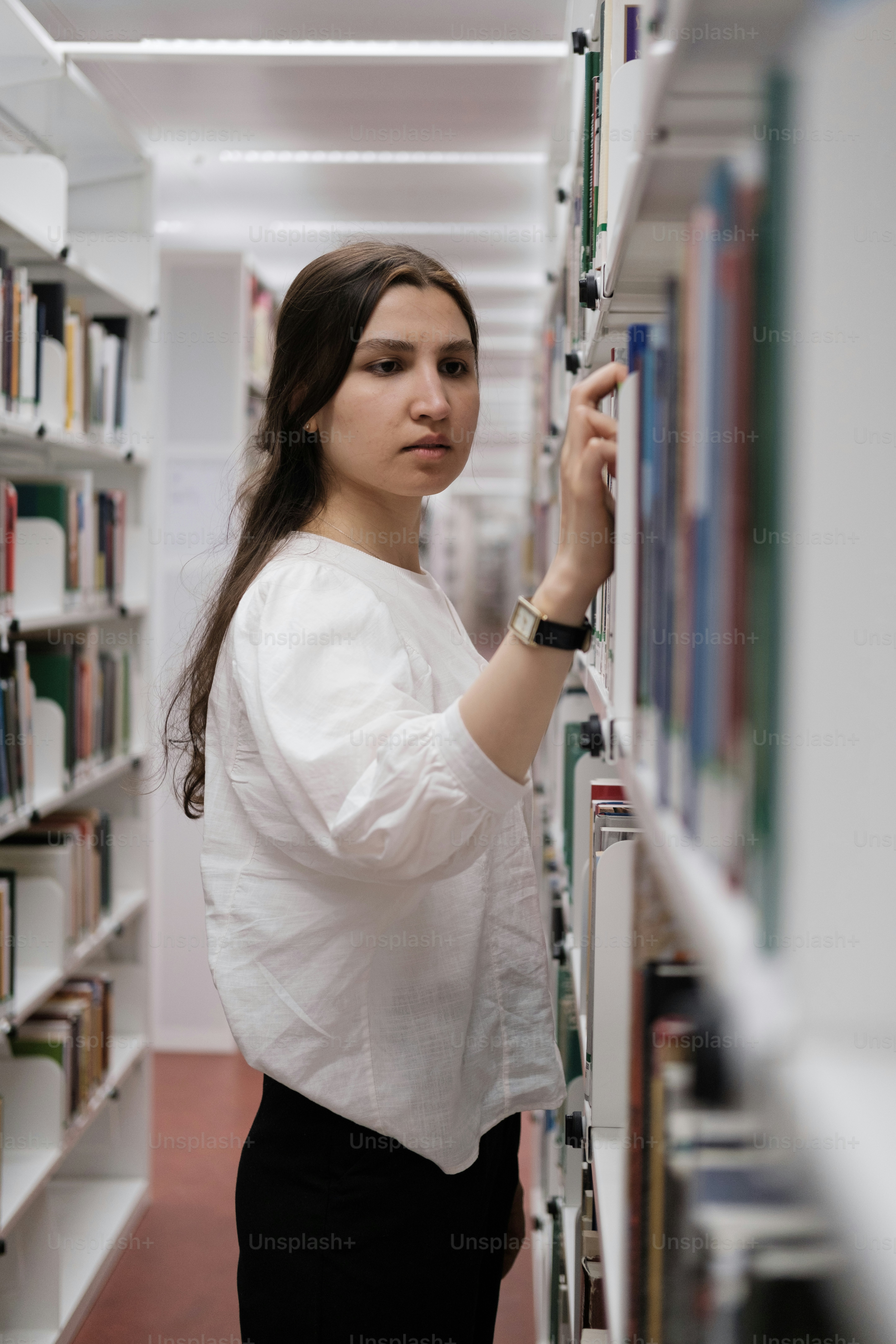 A woman reading a book in a library photo – Learn Image on Unsplash