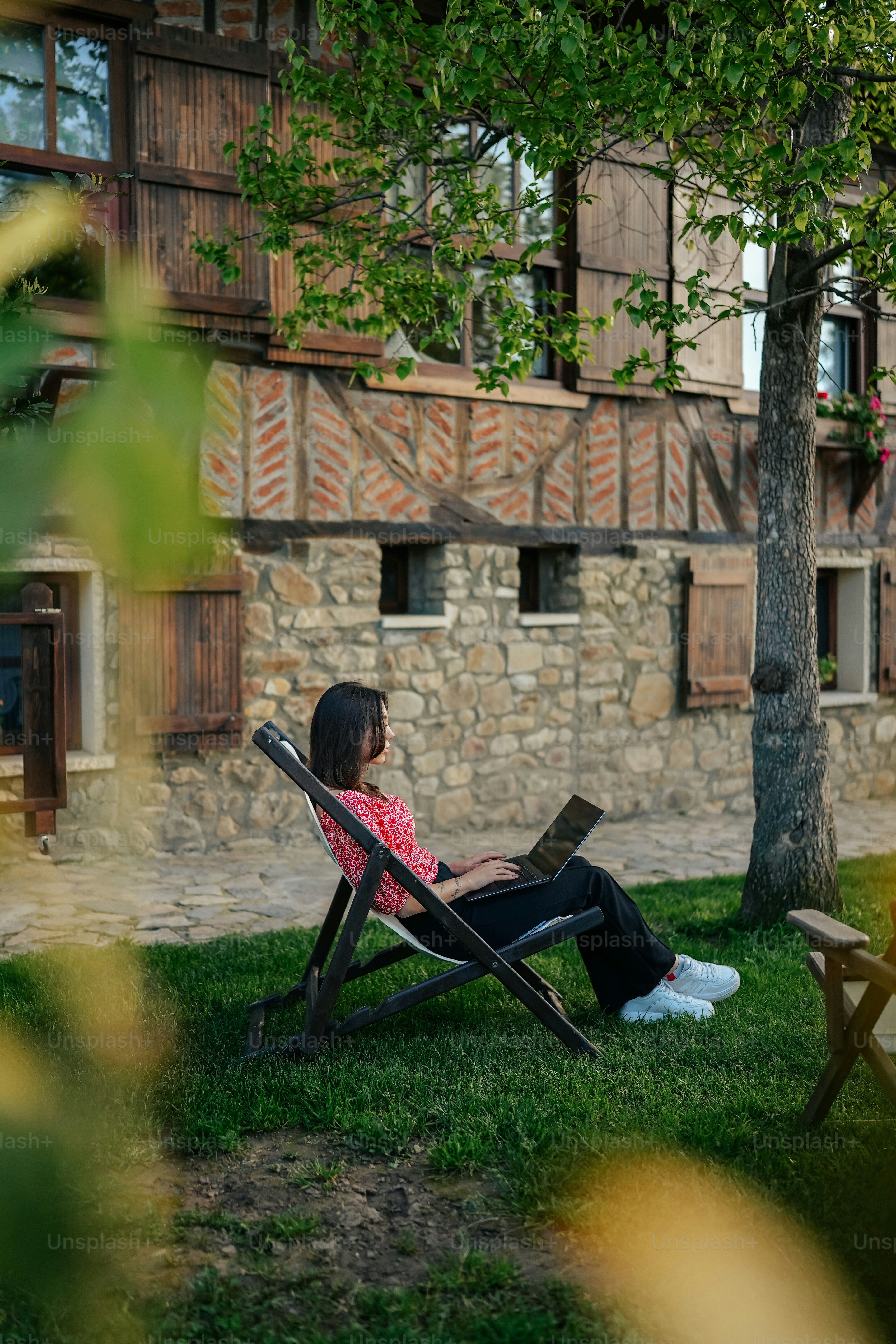 A woman sitting on a lawn chair in front of a building photo – Airbnb ...