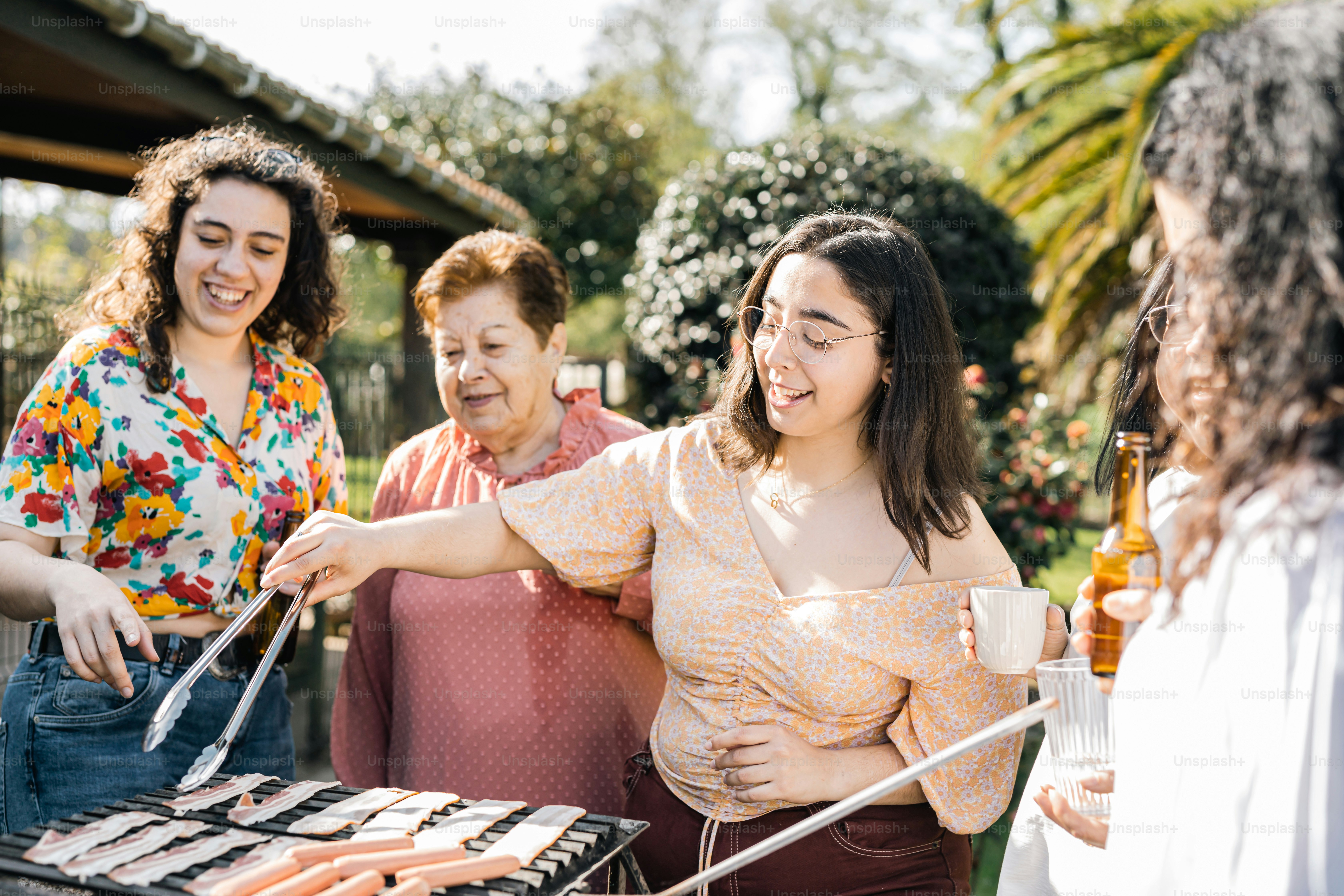 A group of women standing around a bbq grill photo – Family Image on ...