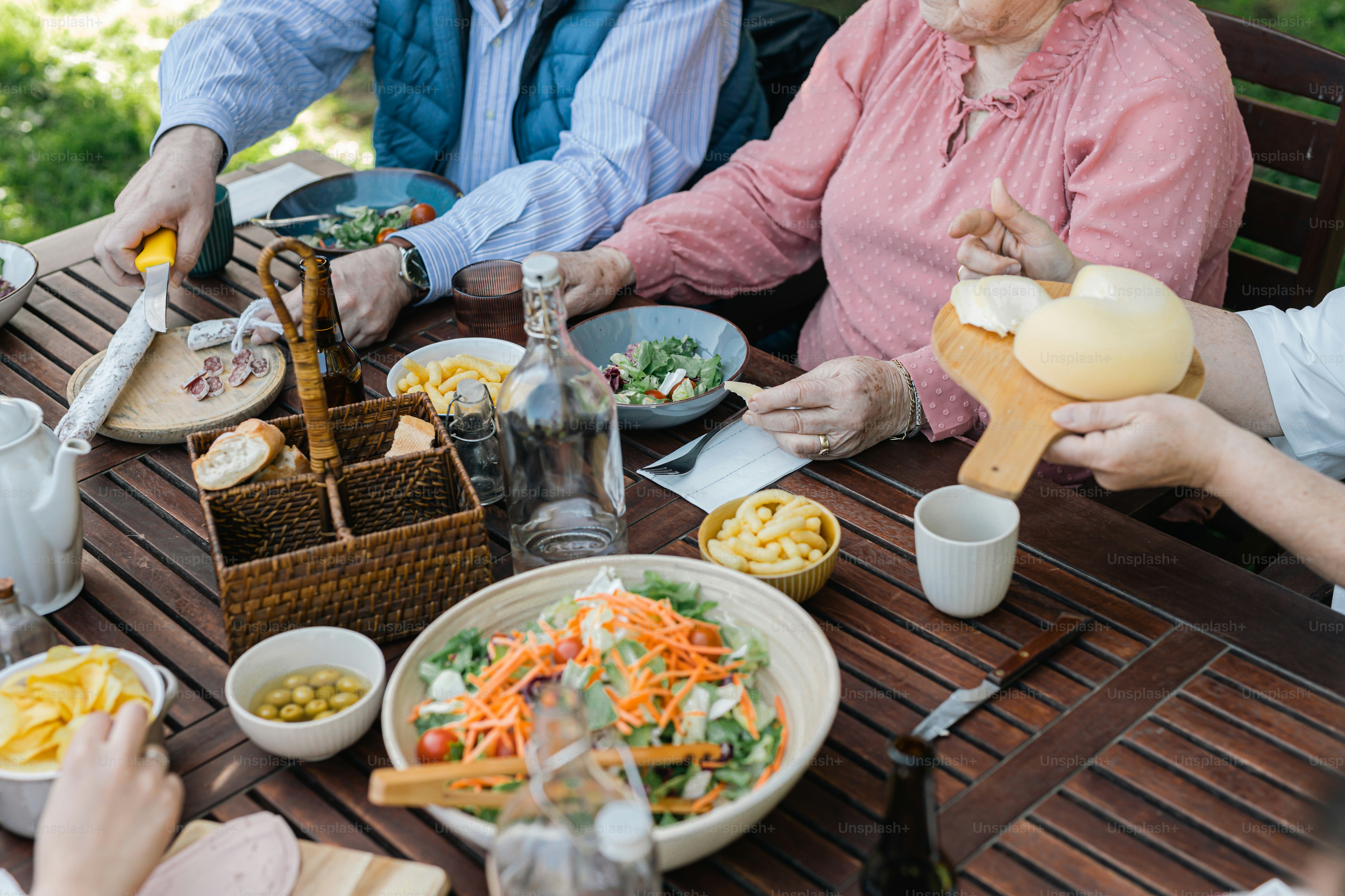 Un grupo de personas sentadas alrededor de una mesa comiendo alimentos ...