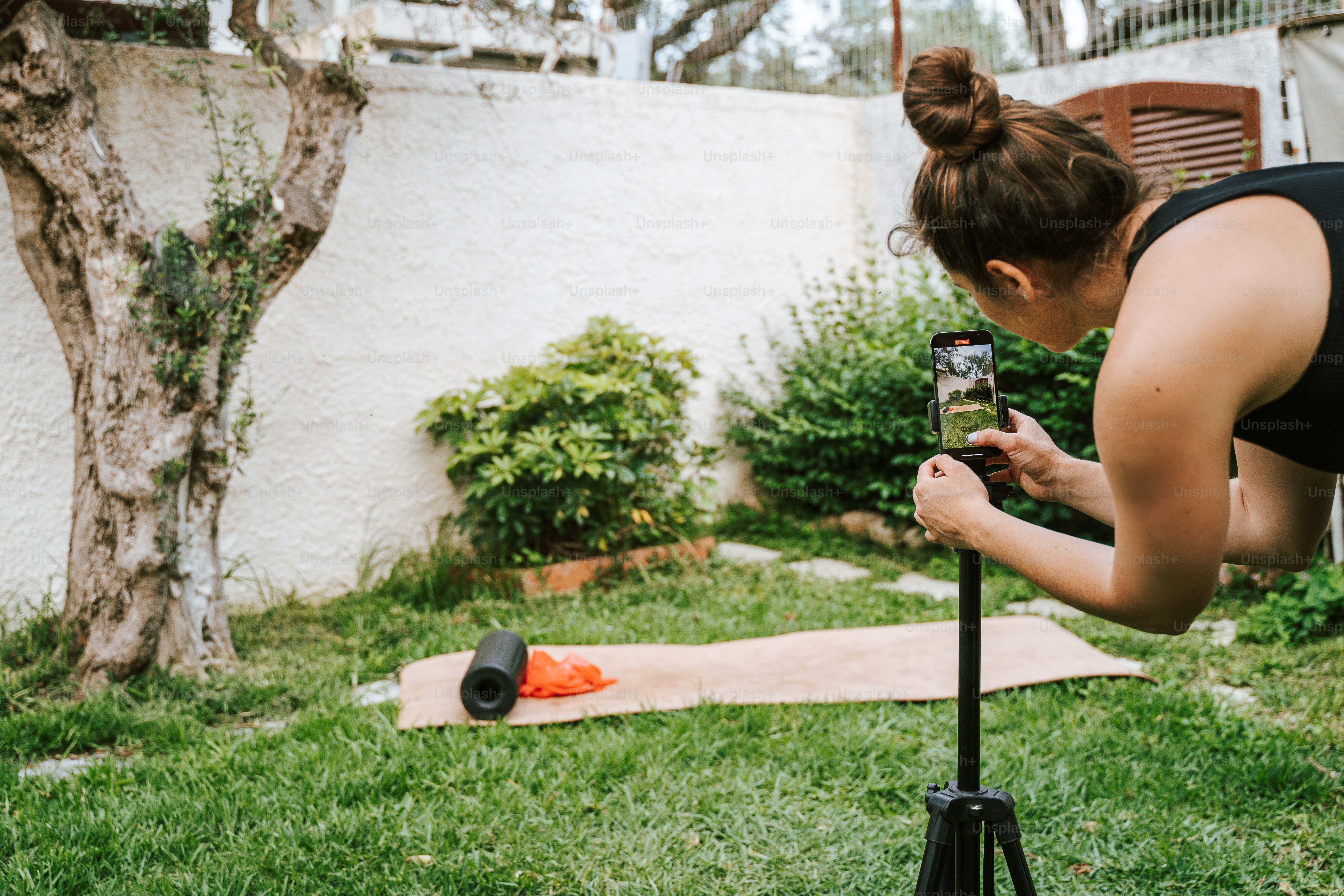 A woman taking a picture of herself in a backyard photo – Editing video Image on Unsplash
