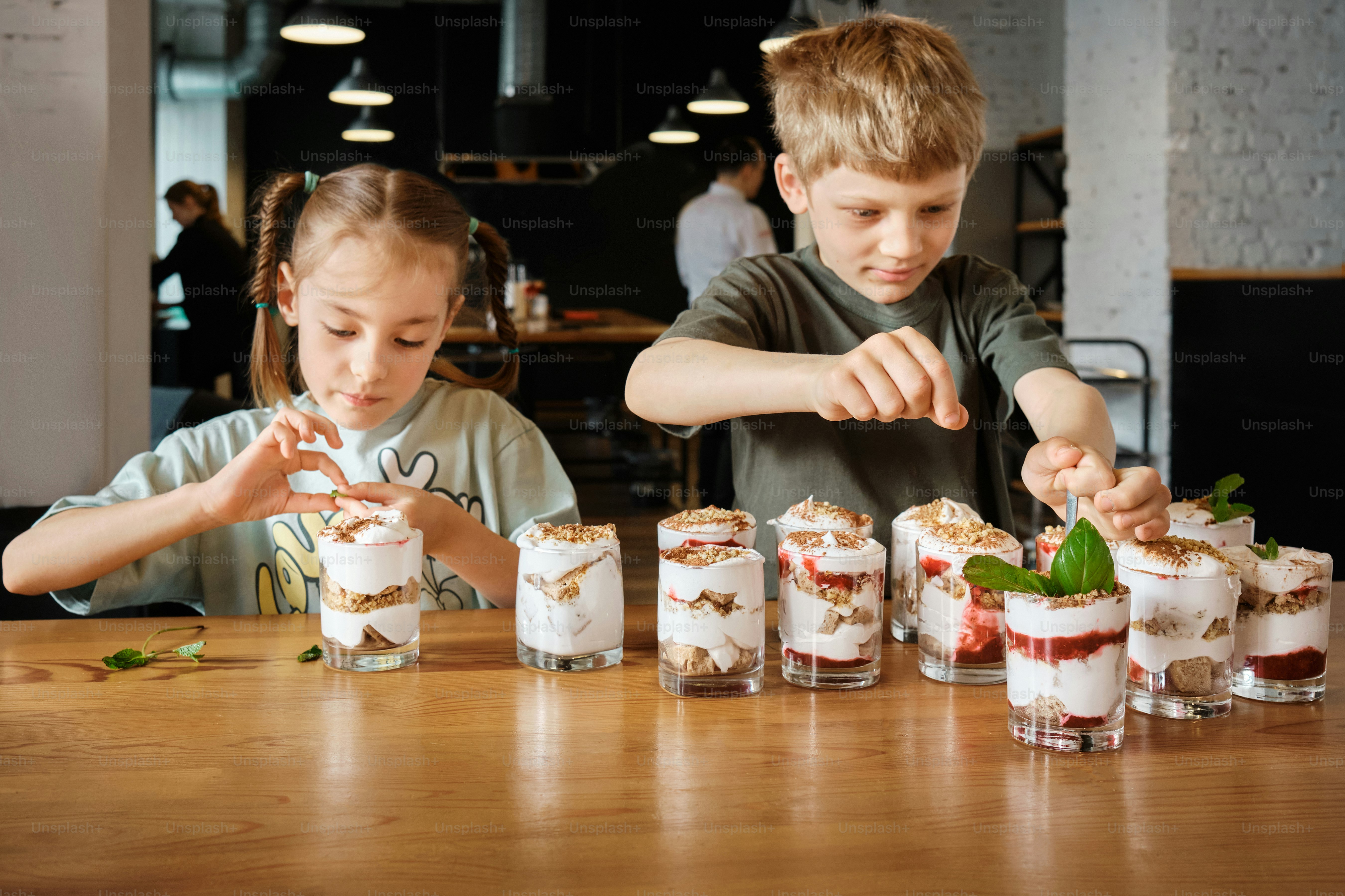 A boy and a girl making desserts at a table photo – Learning Image on ...