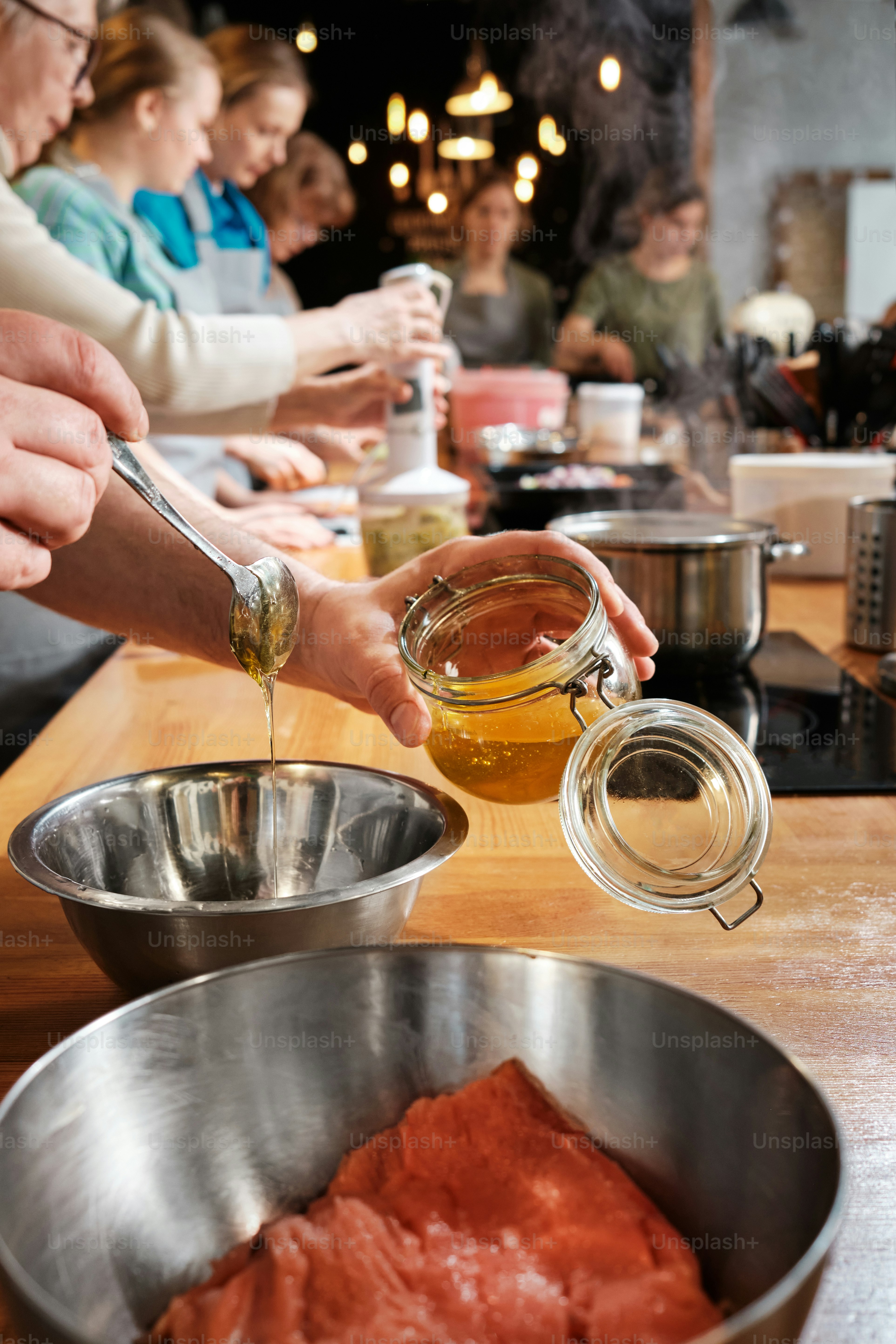 A group of people standing around a table with food photo – Cooking ...