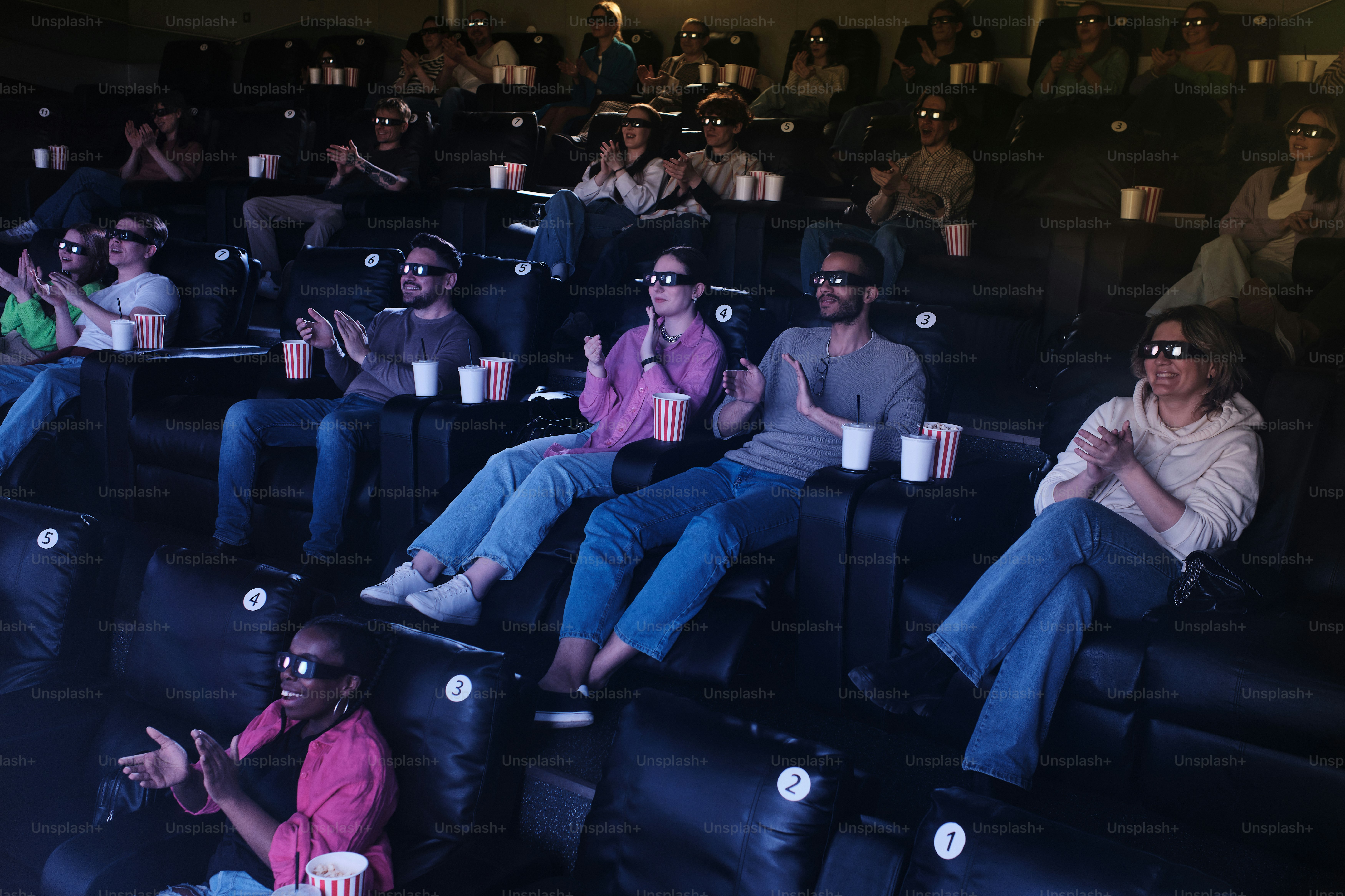 A group of people sitting in a movie theater photo – Applauding Image ...