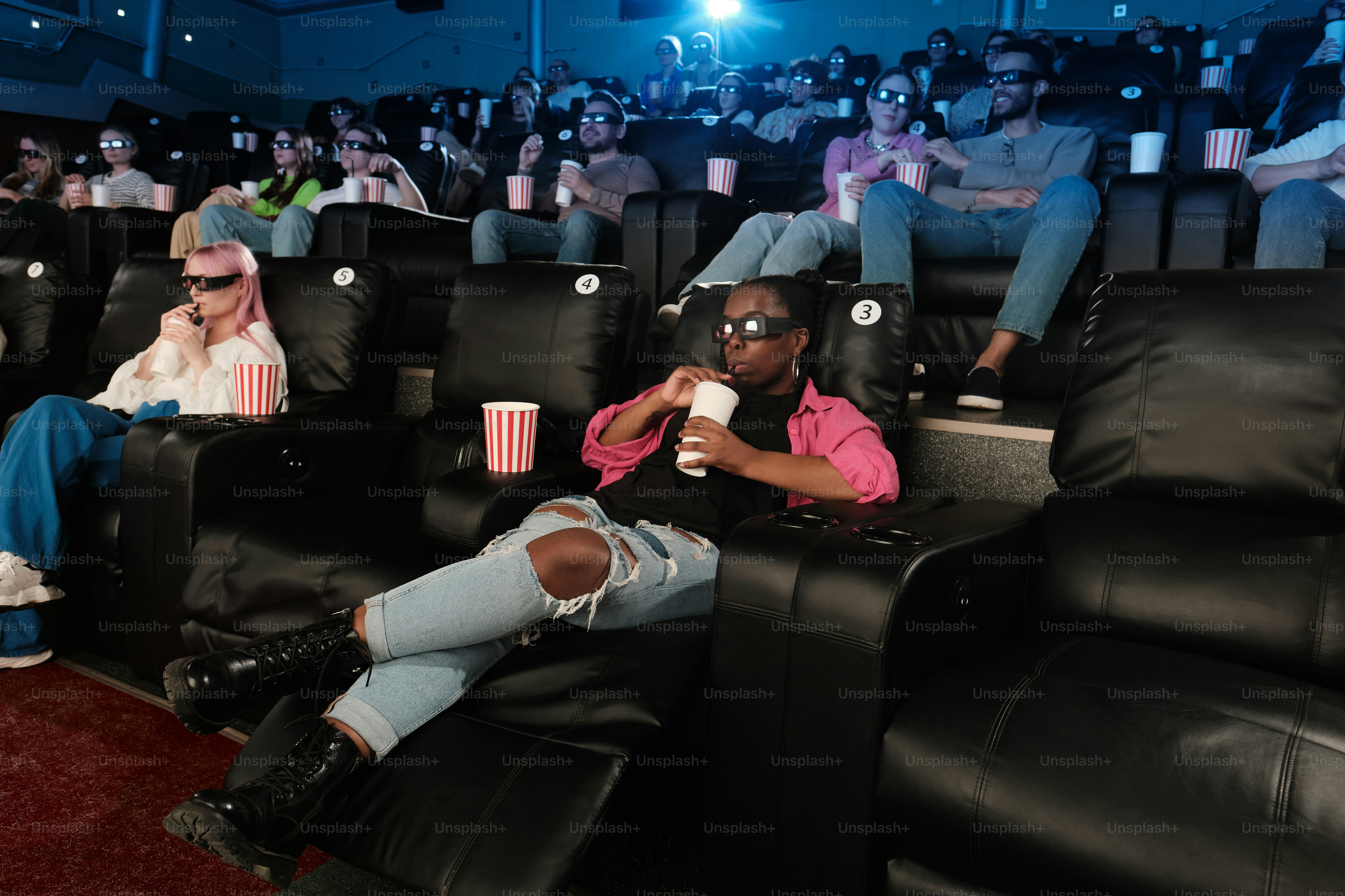 A group of people sitting in a movie theater photo – Audience Image on ...