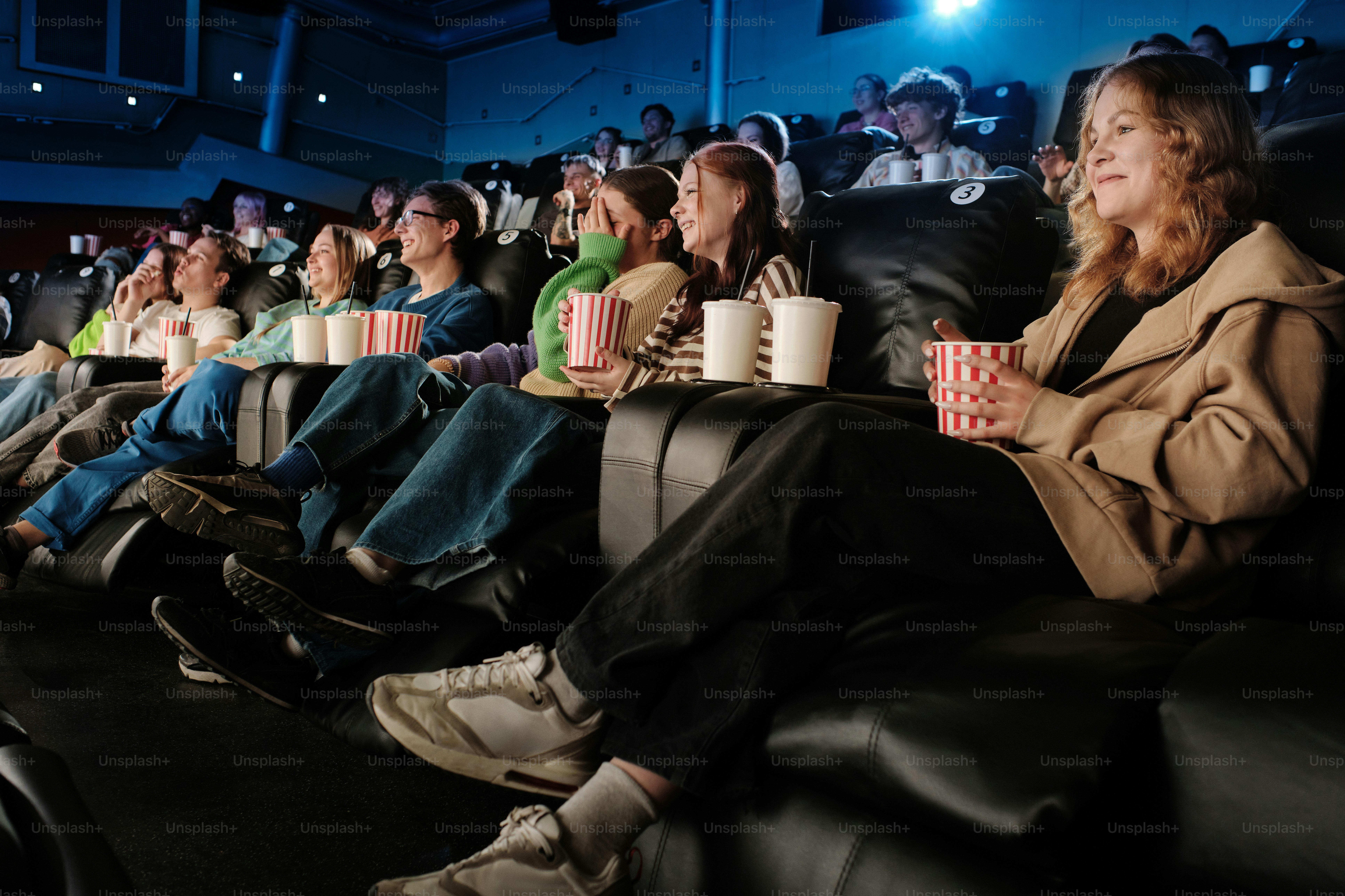 A group of people sitting in a movie theater photo – Movie Image on ...