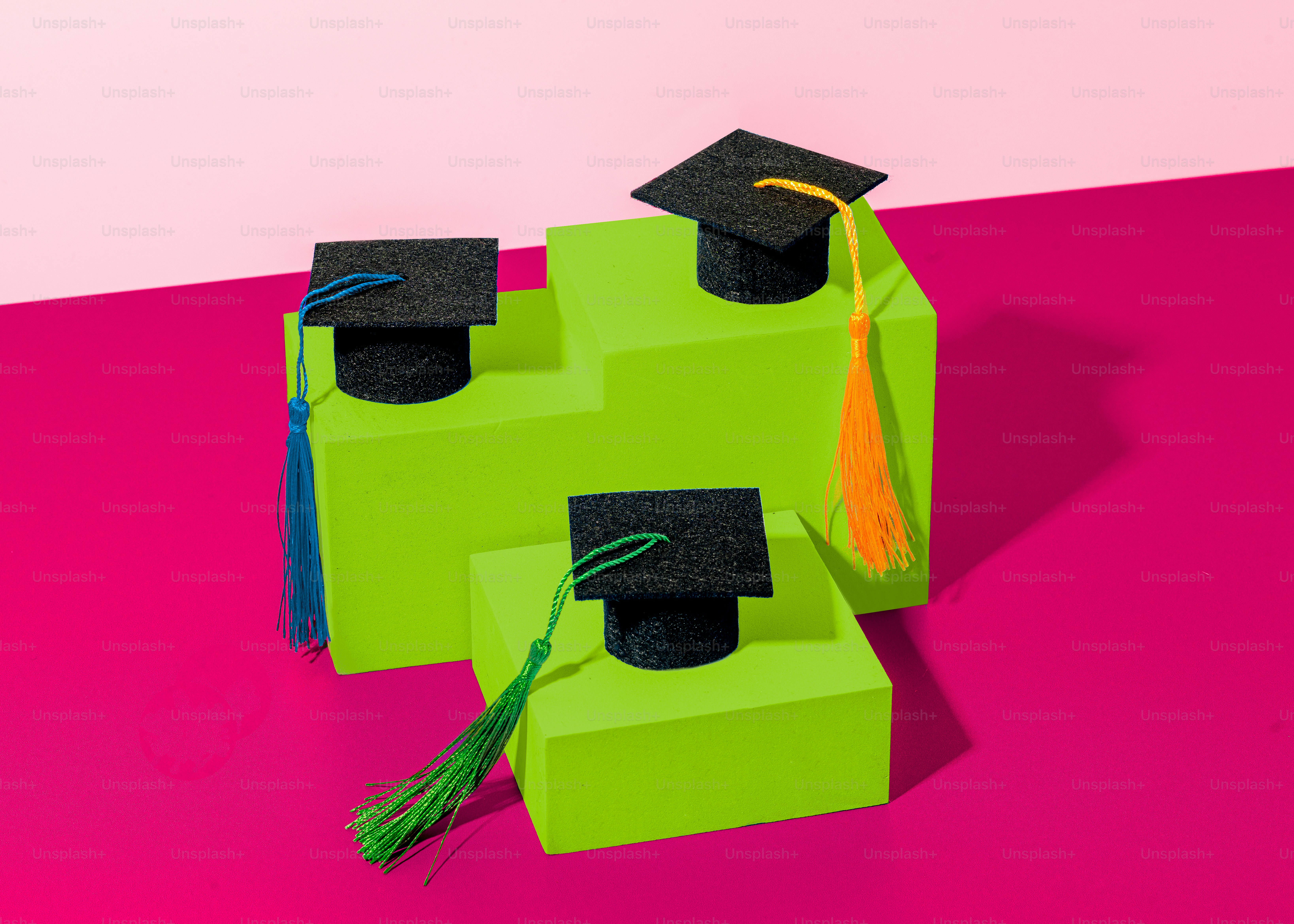 A pair of graduation caps sitting on top of green blocks photo – Mortar ...