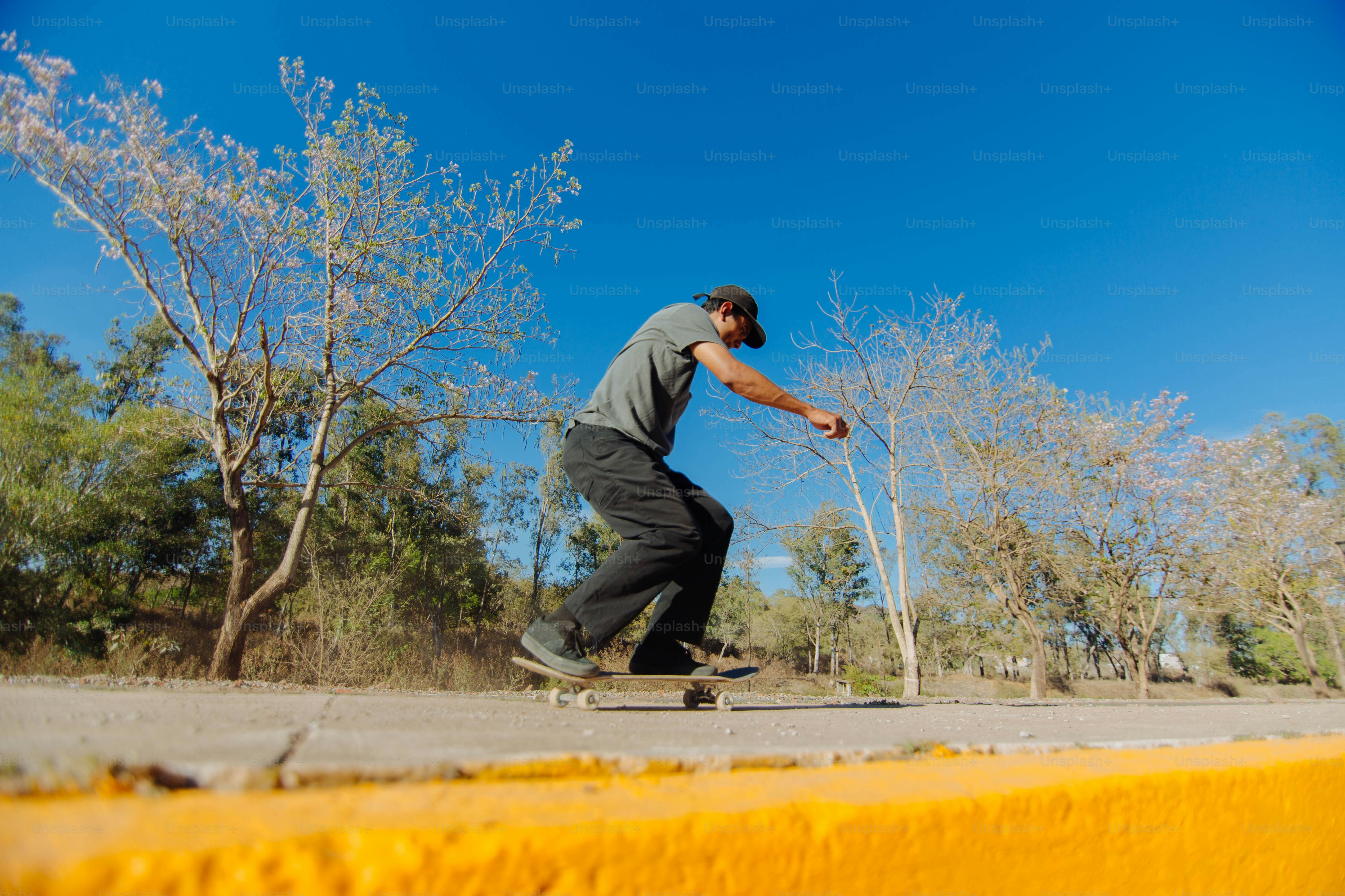 A man riding a skateboard down the side of a road photo – Outdoor ...