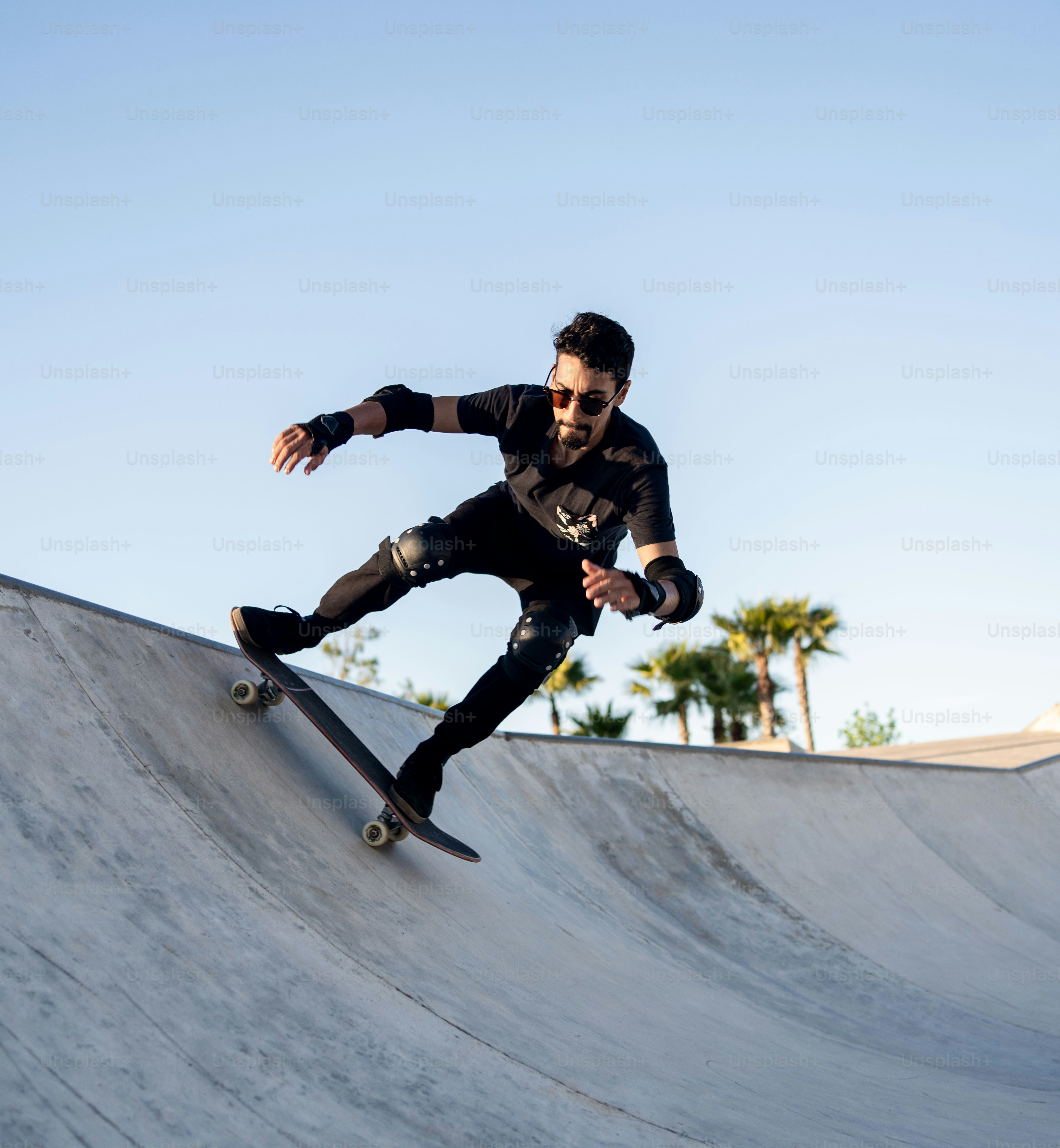 A man riding a skateboard up the side of a ramp photo – Skateboarding ...