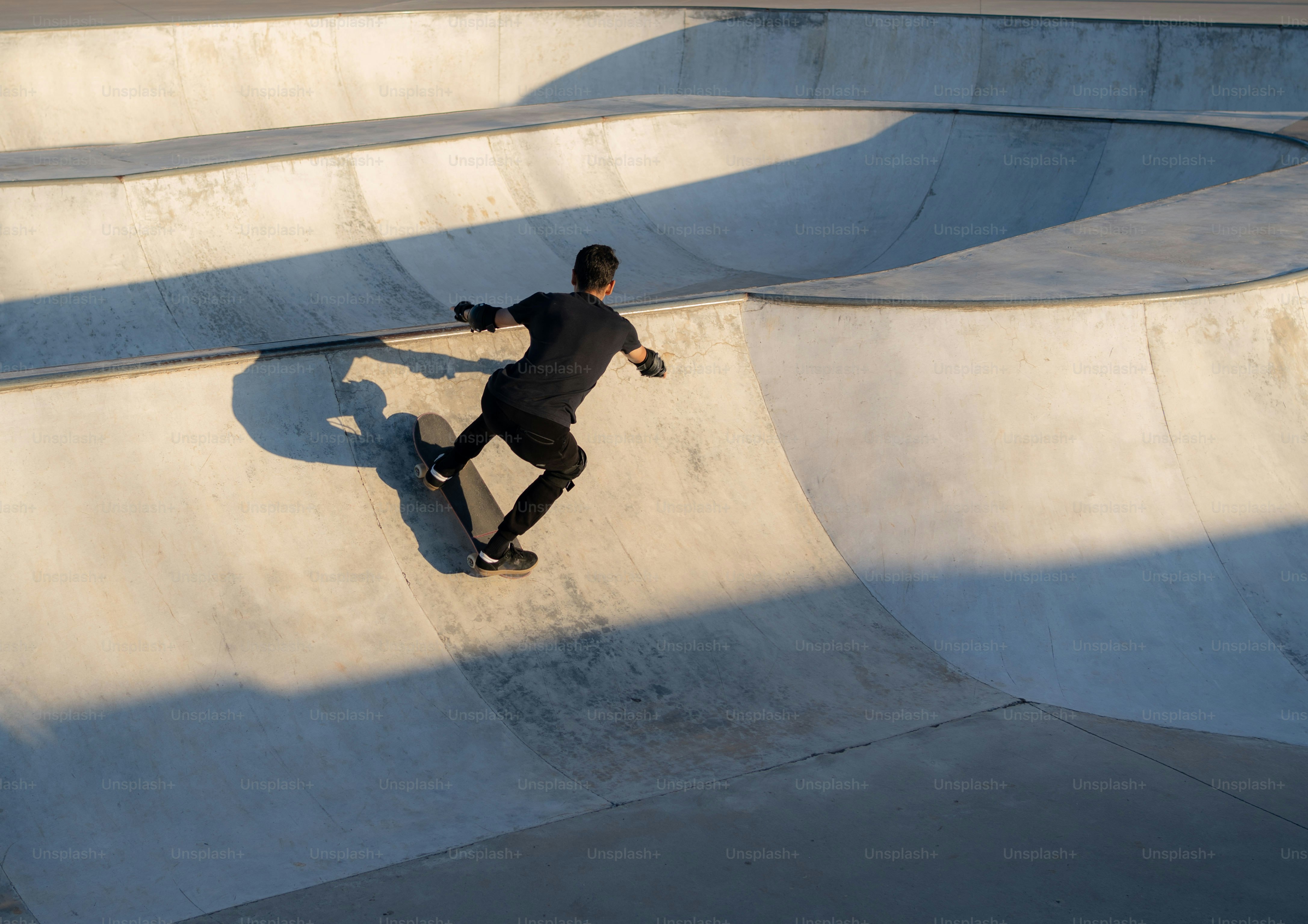 A man riding a skateboard up the side of a ramp photo – Skateboarding ...