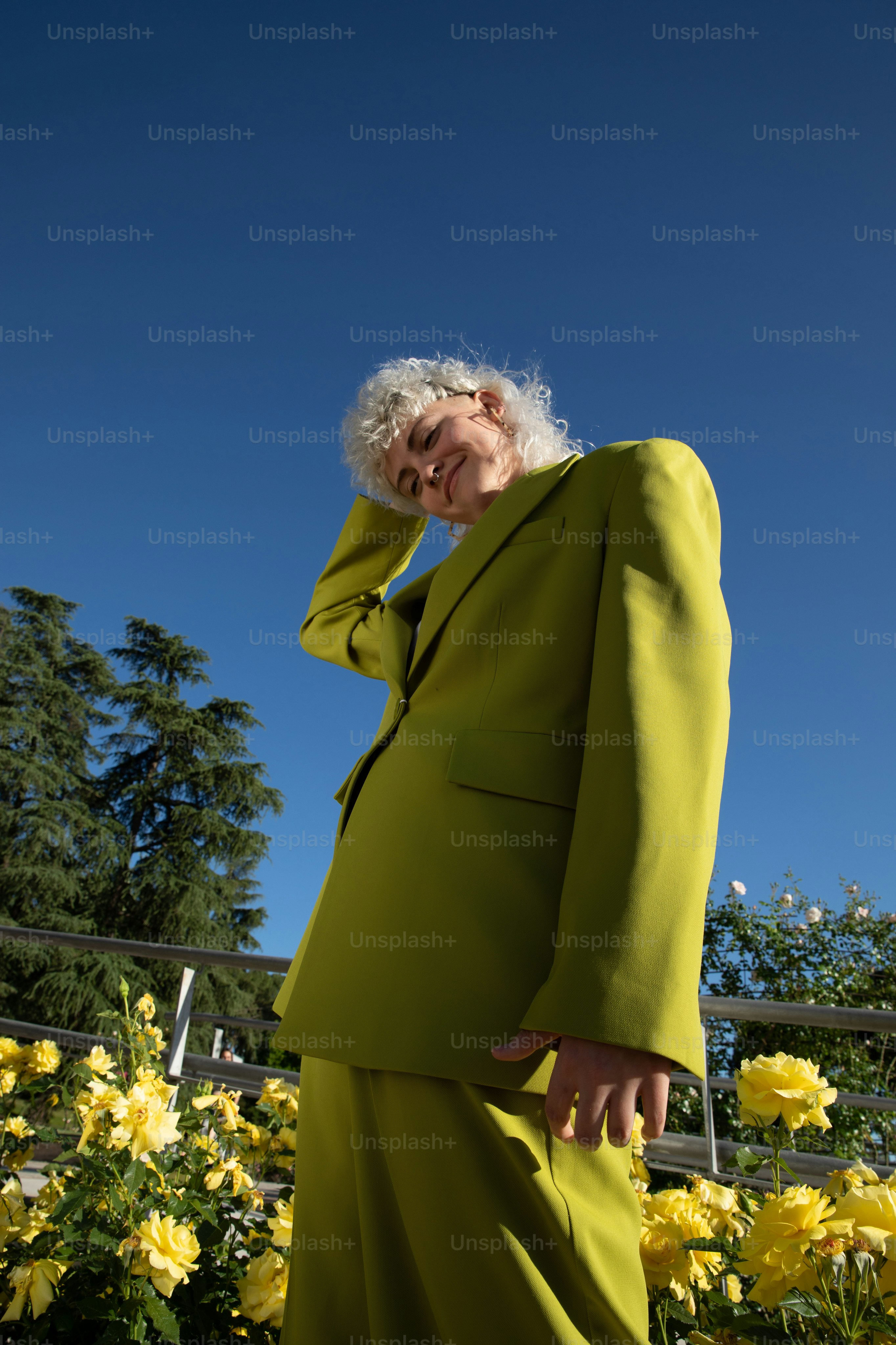 Une femme en costume jaune se tient debout dans un champ de fleurs ...