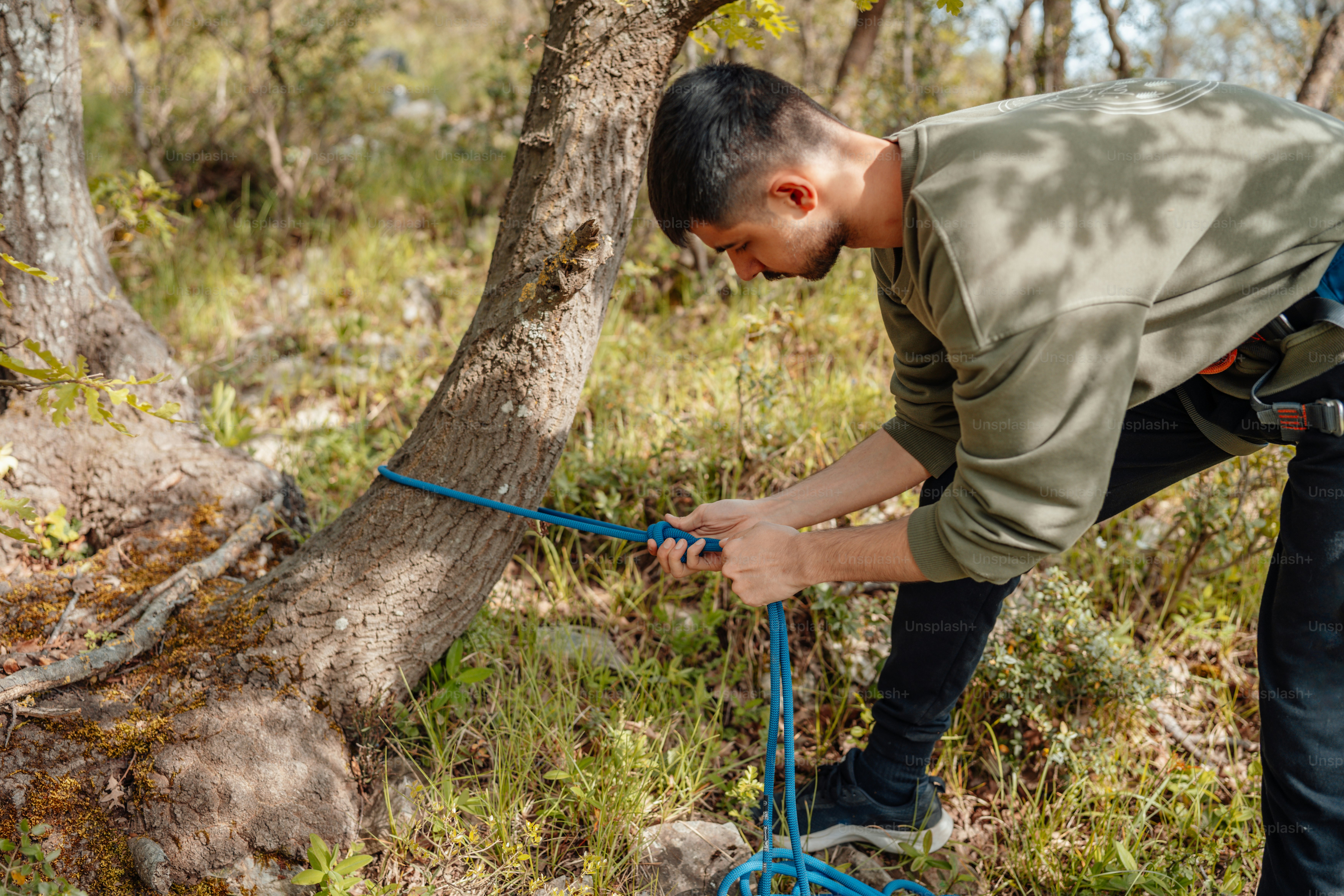 A man with a rope attached to a tree photo – Outdoor sports Image on ...