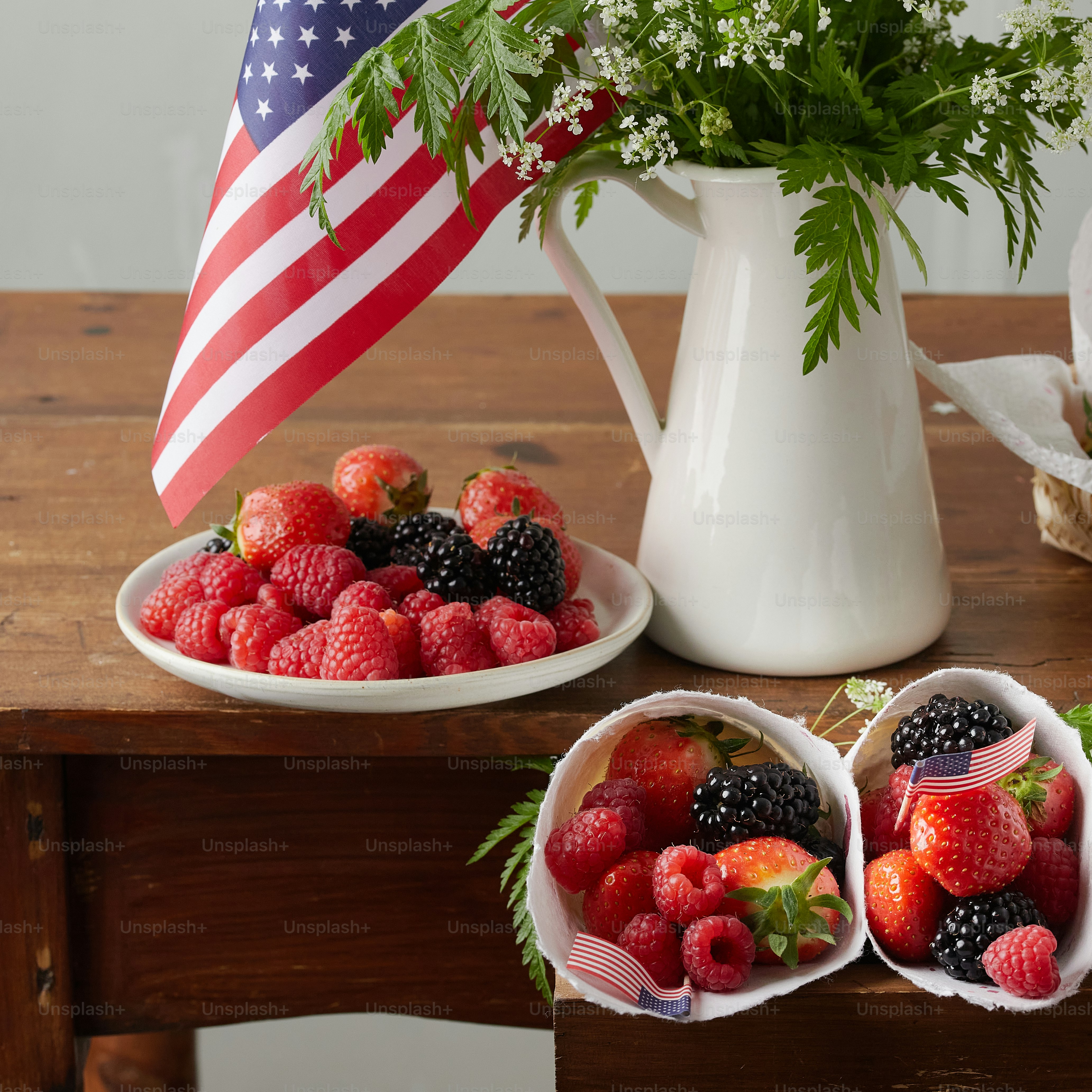 A table topped with plates of fruit and a vase filled with flowers ...