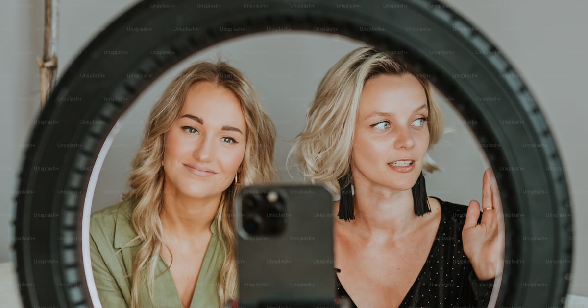 Deux Femmes Assises Sur Un Canapé Avec Une Caméra Devant Elles Photo