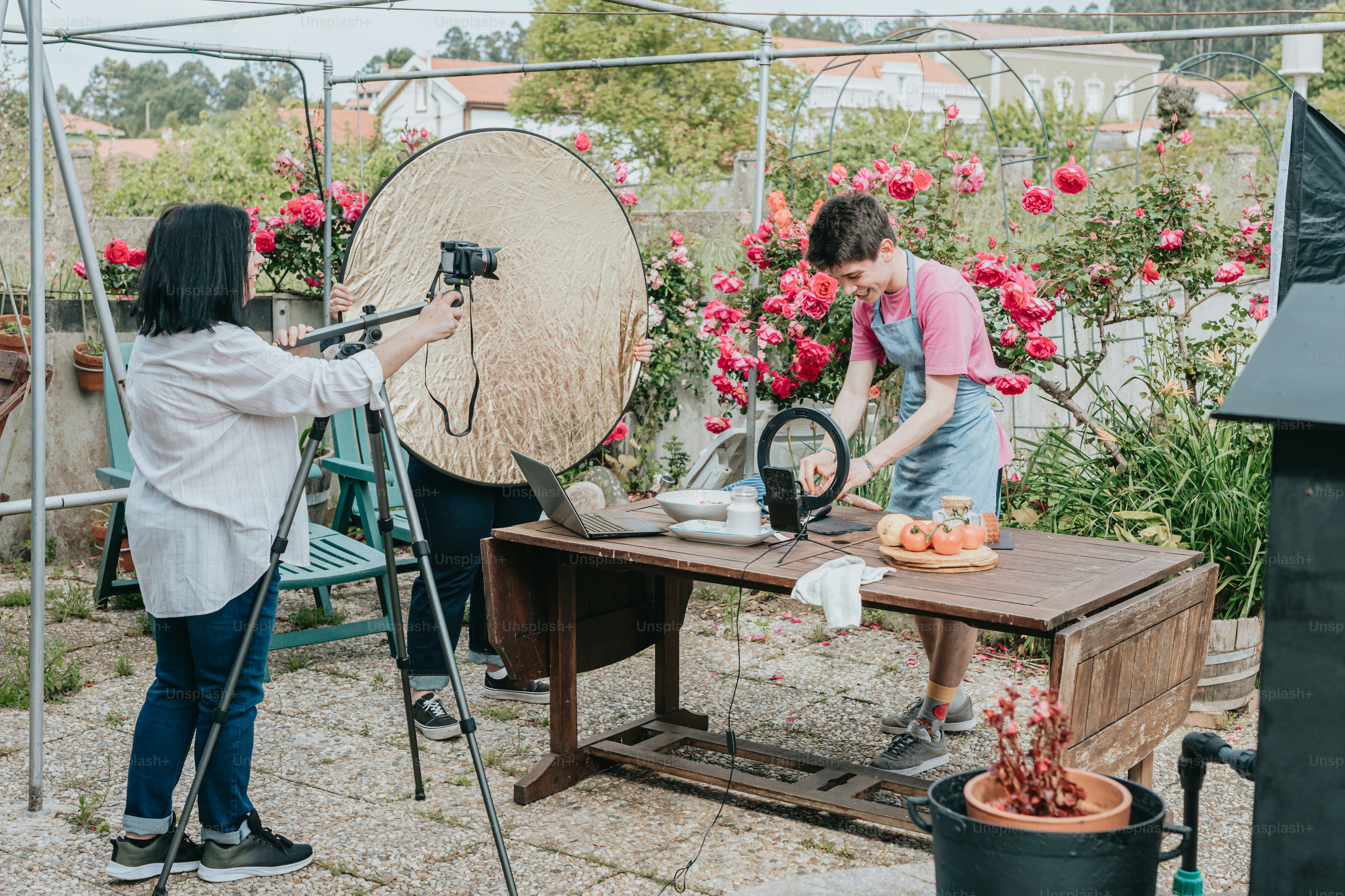 A woman is filming another woman in a garden photo – Content creator ...