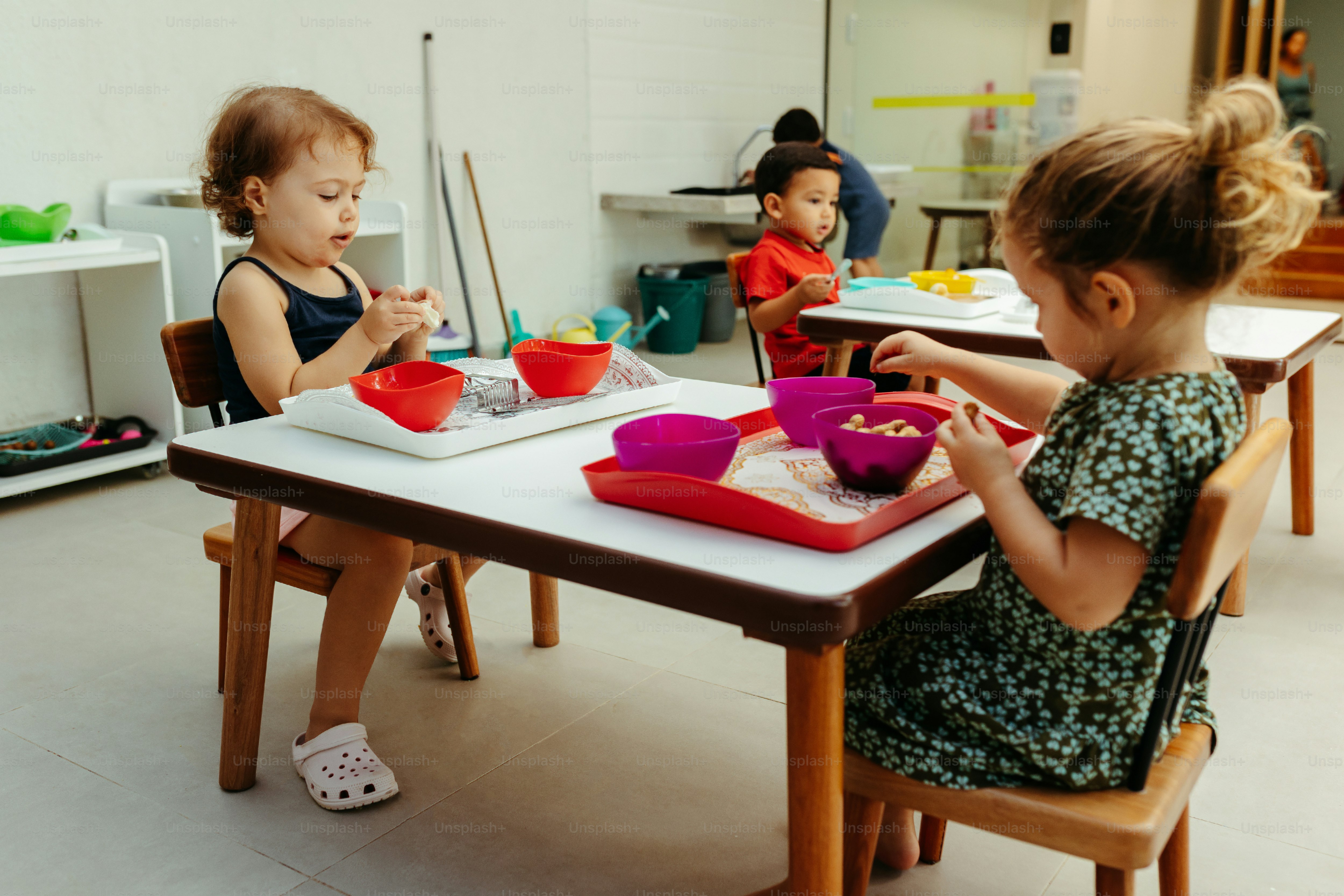 A group of children sitting at a table eating photo – Pre school Image ...