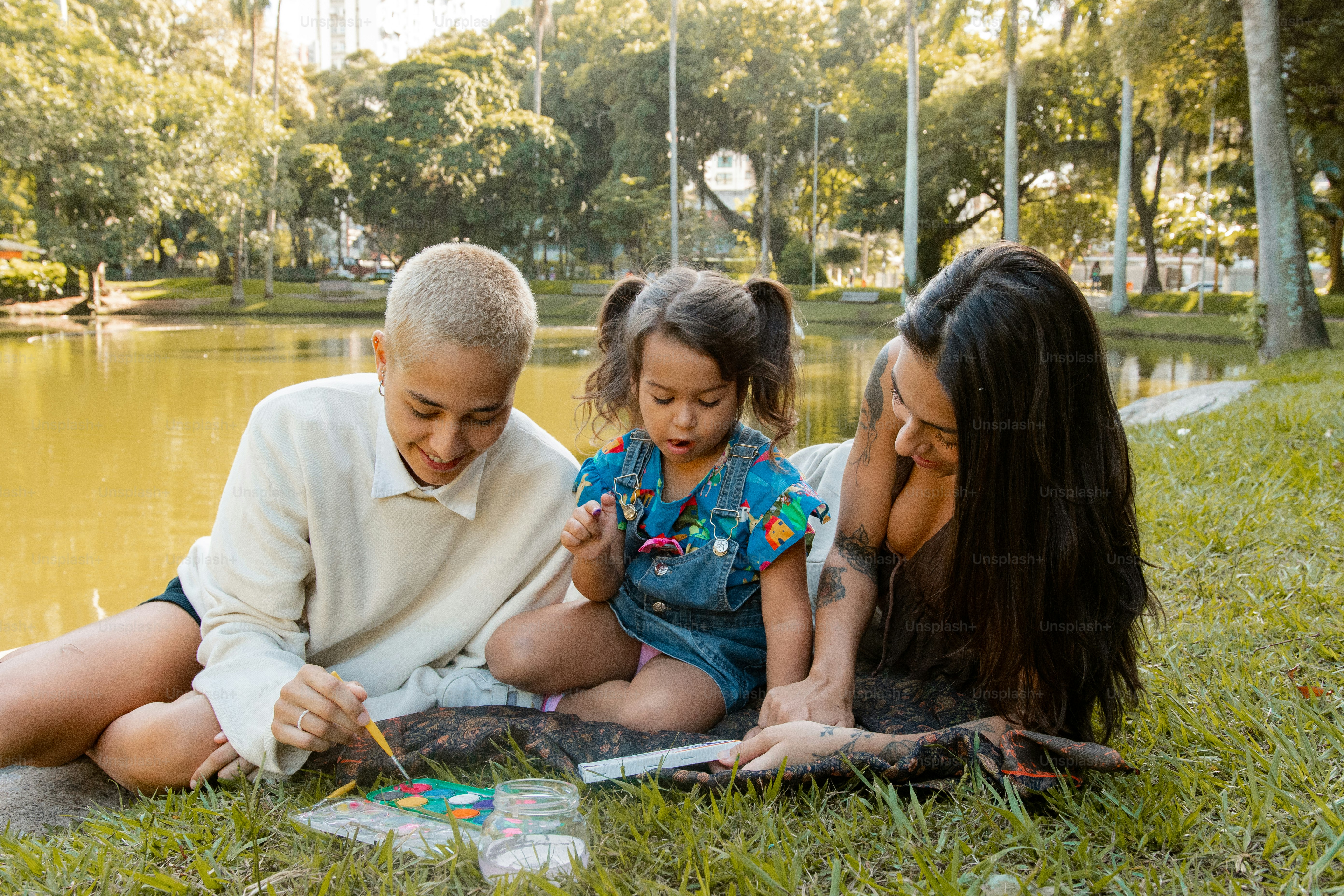 A woman and two children sitting on a swing photo – Lgbt family Image ...