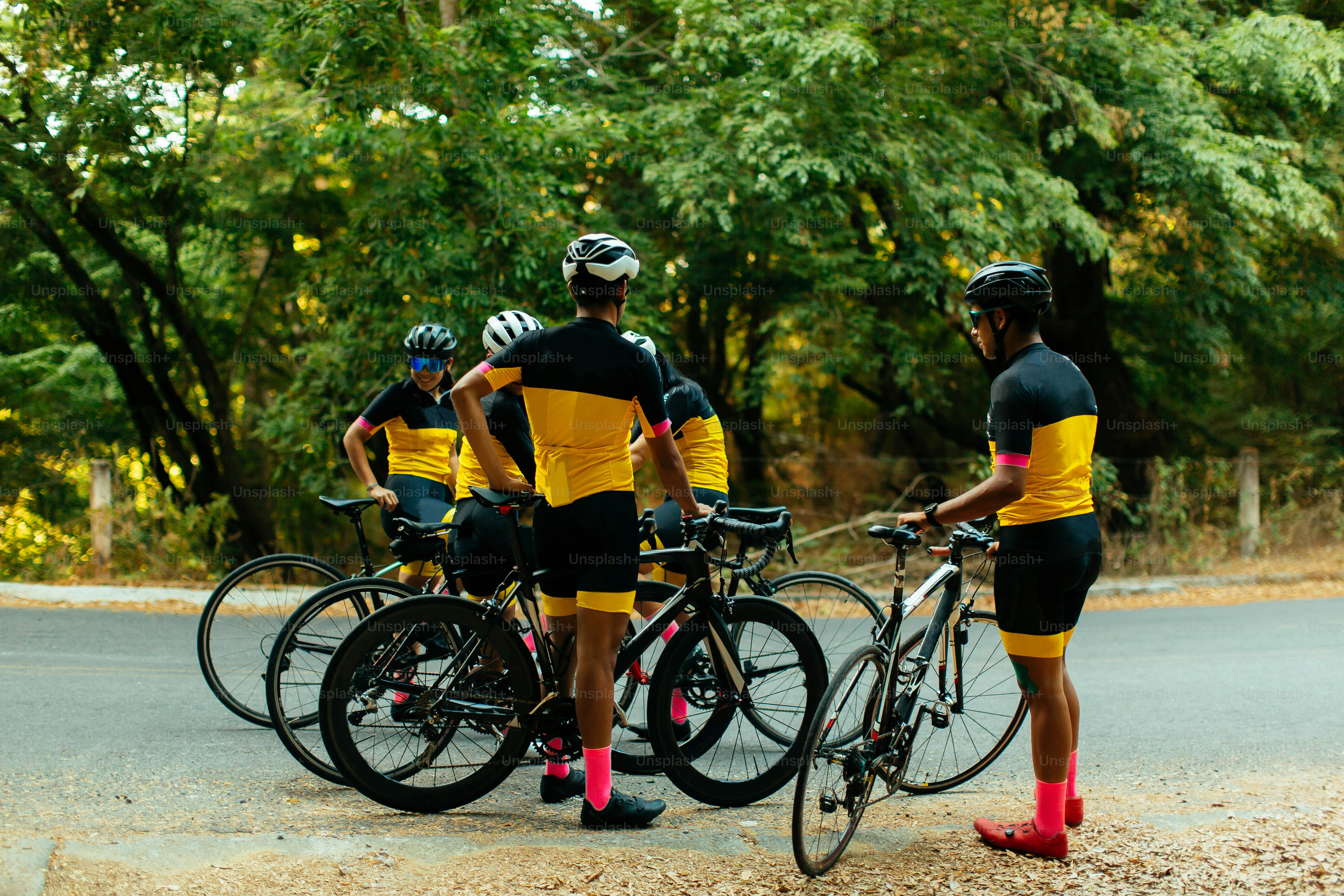 A group of people riding bikes down a road photo – Cycling Image on ...