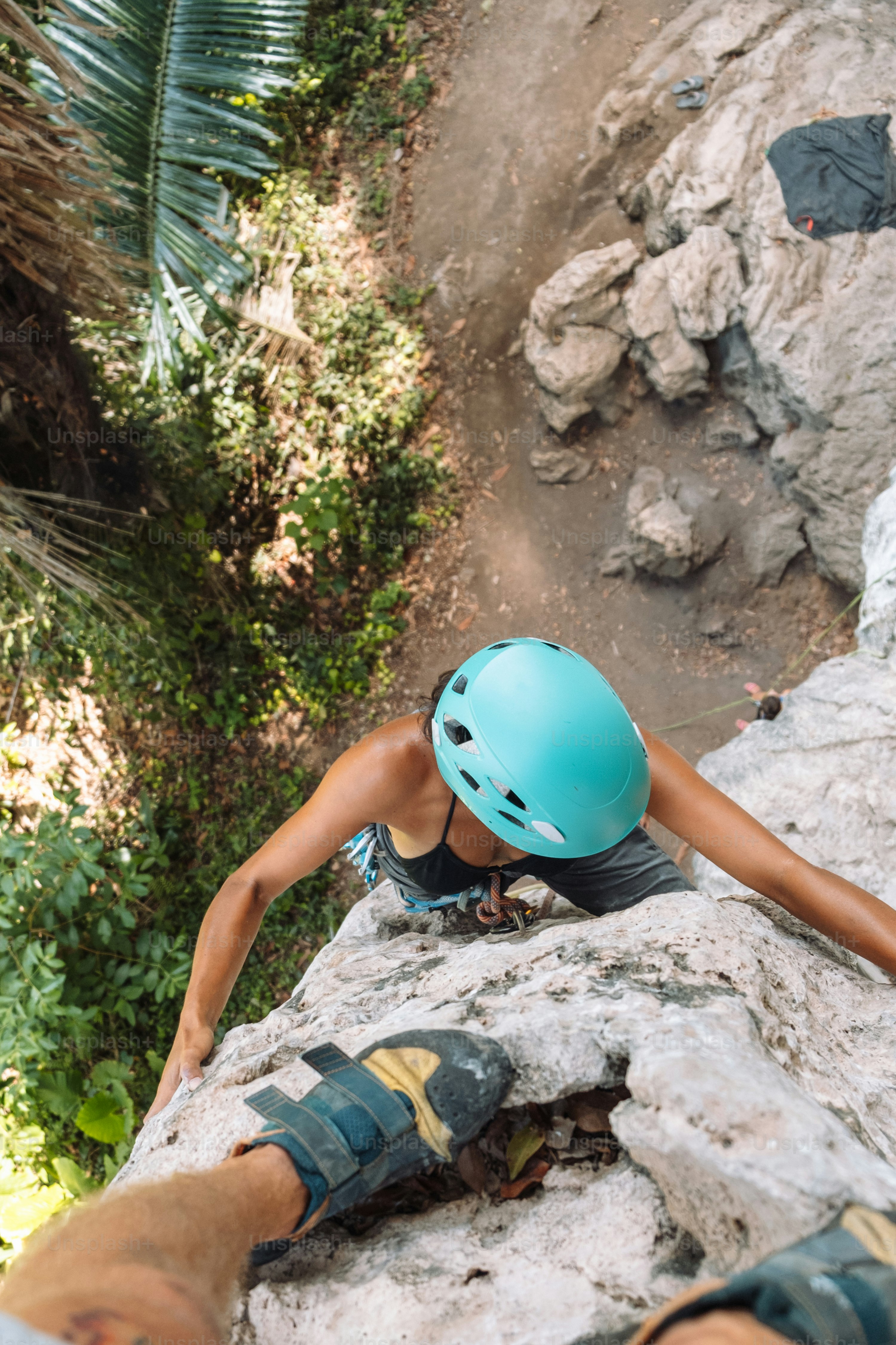 A woman climbing up the side of a cliff photo – Rock climber Image on ...