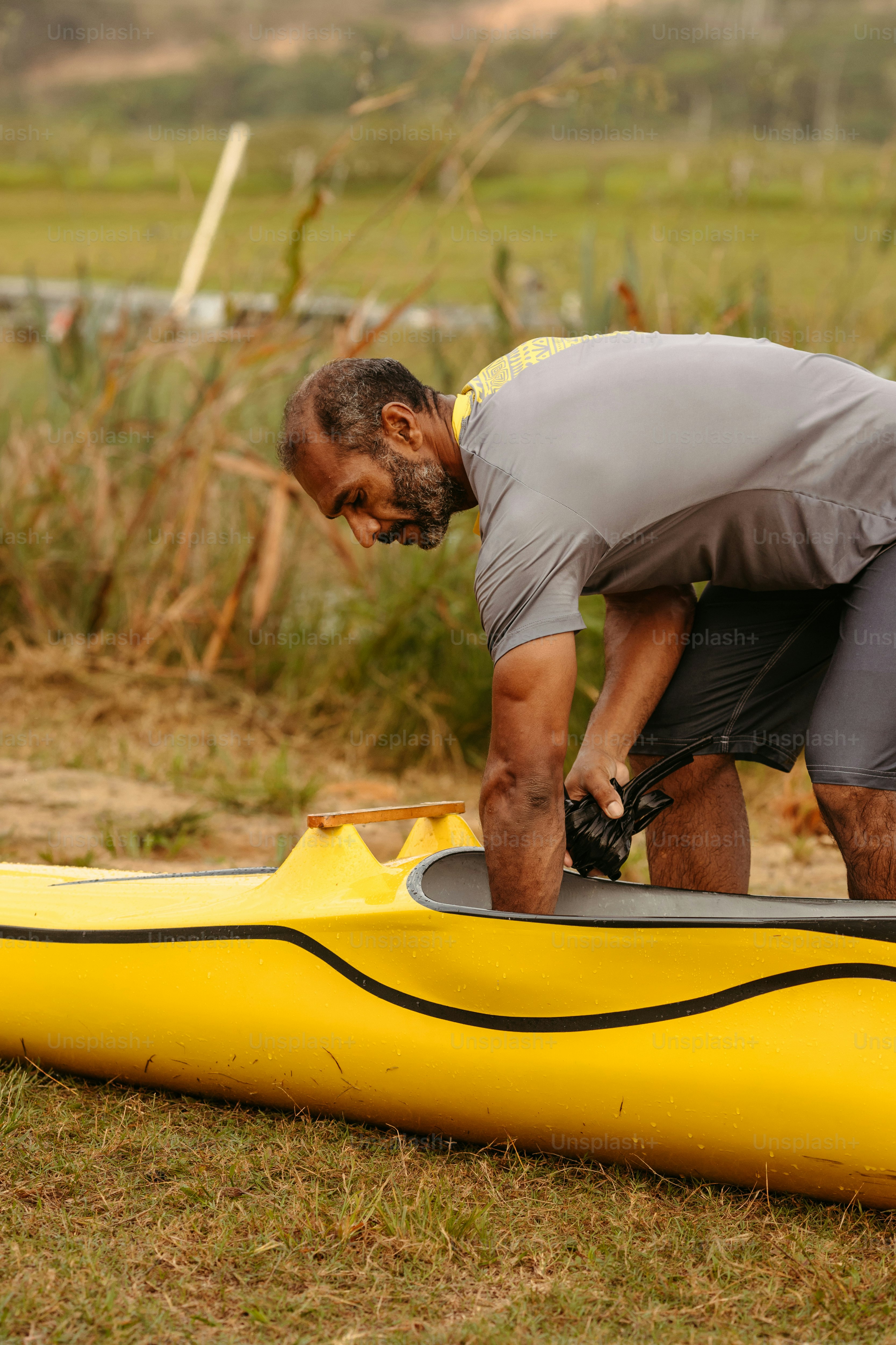 A man working on a kayak on the ground photo – Kayak Image on Unsplash