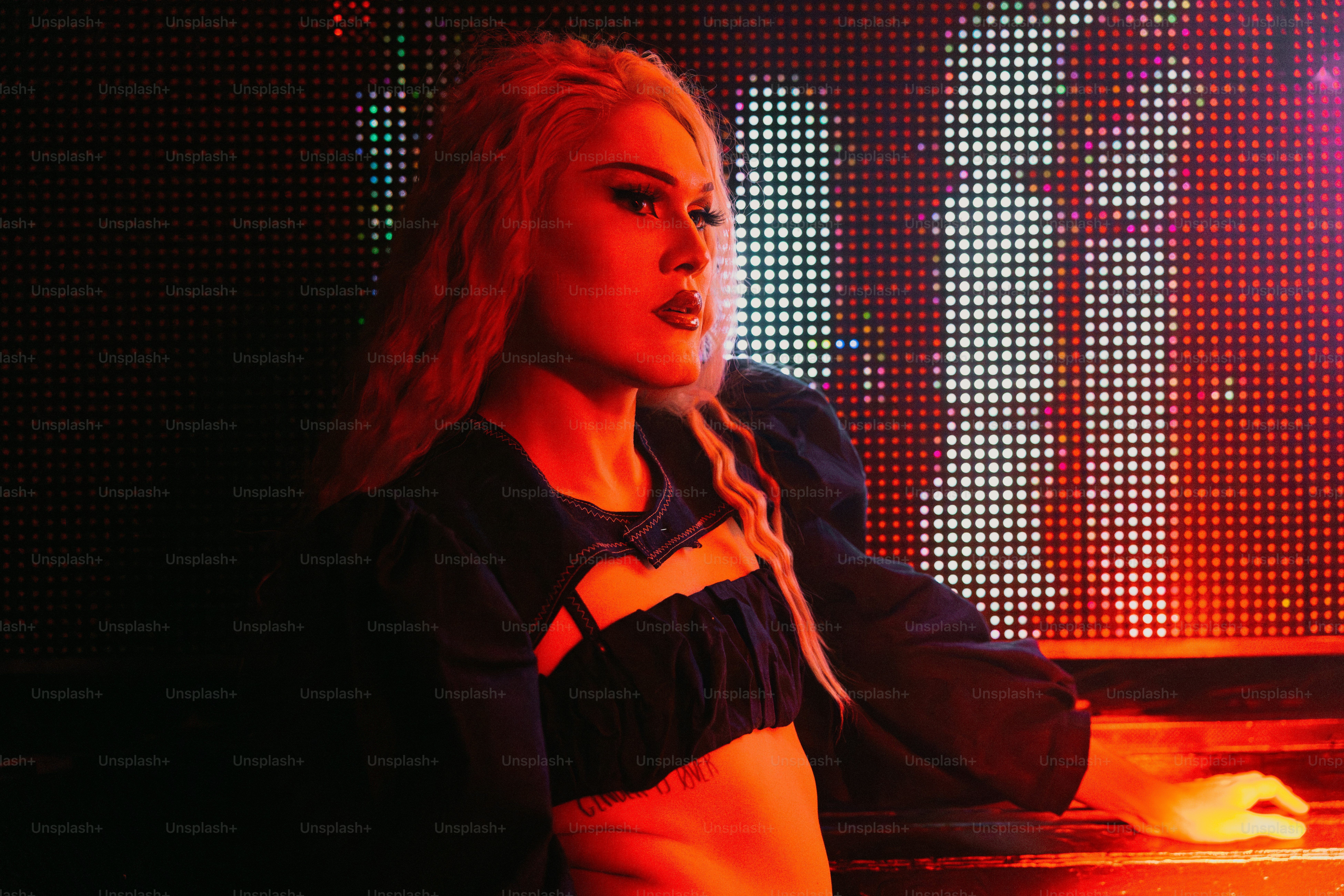 A woman sitting on a stool in front of a screen photo – Drag show Image on Unsplash