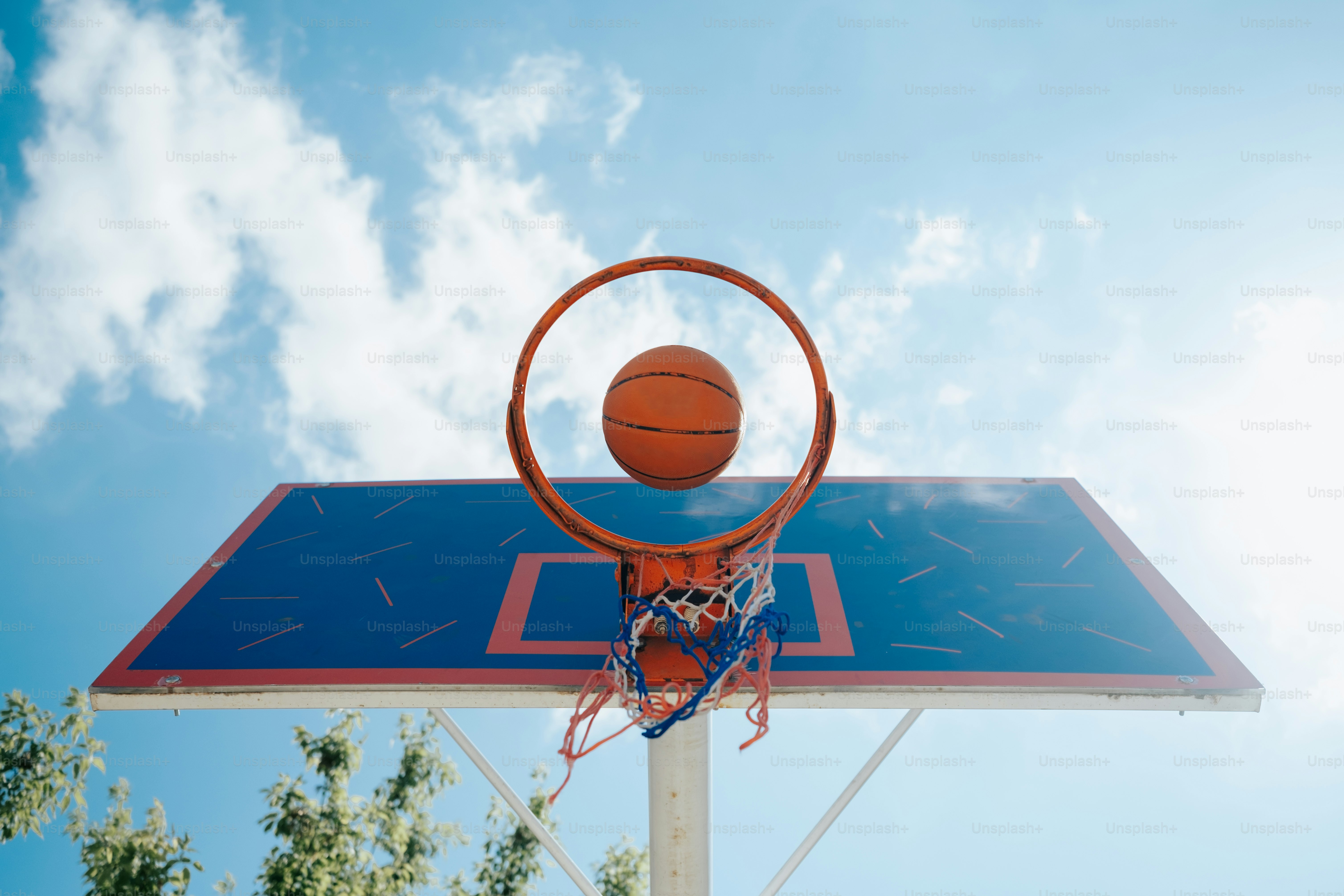 A basketball going through the hoop on a sunny day photo – Shooting ...