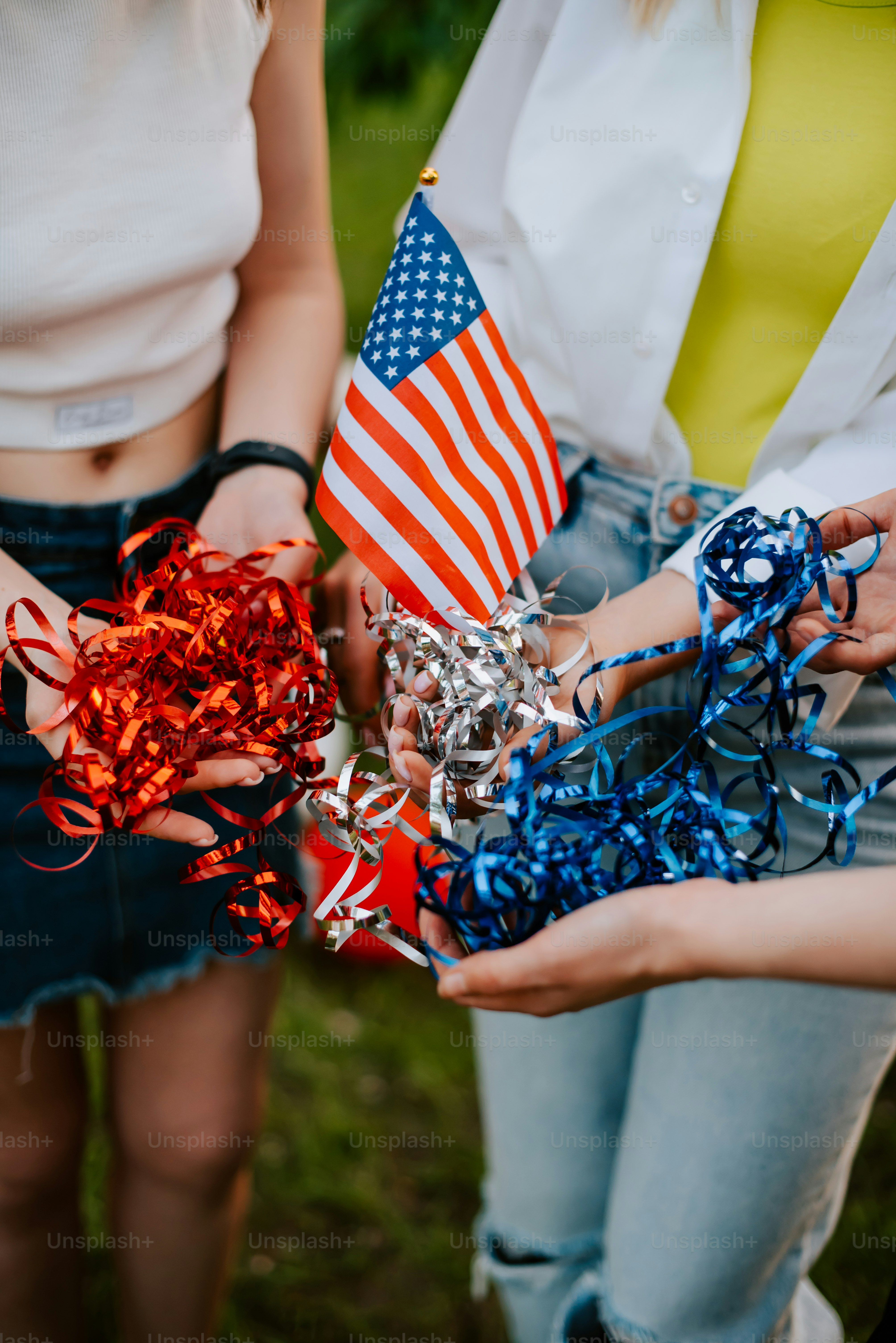 A group of people holding american flags and streamers photo – American ...