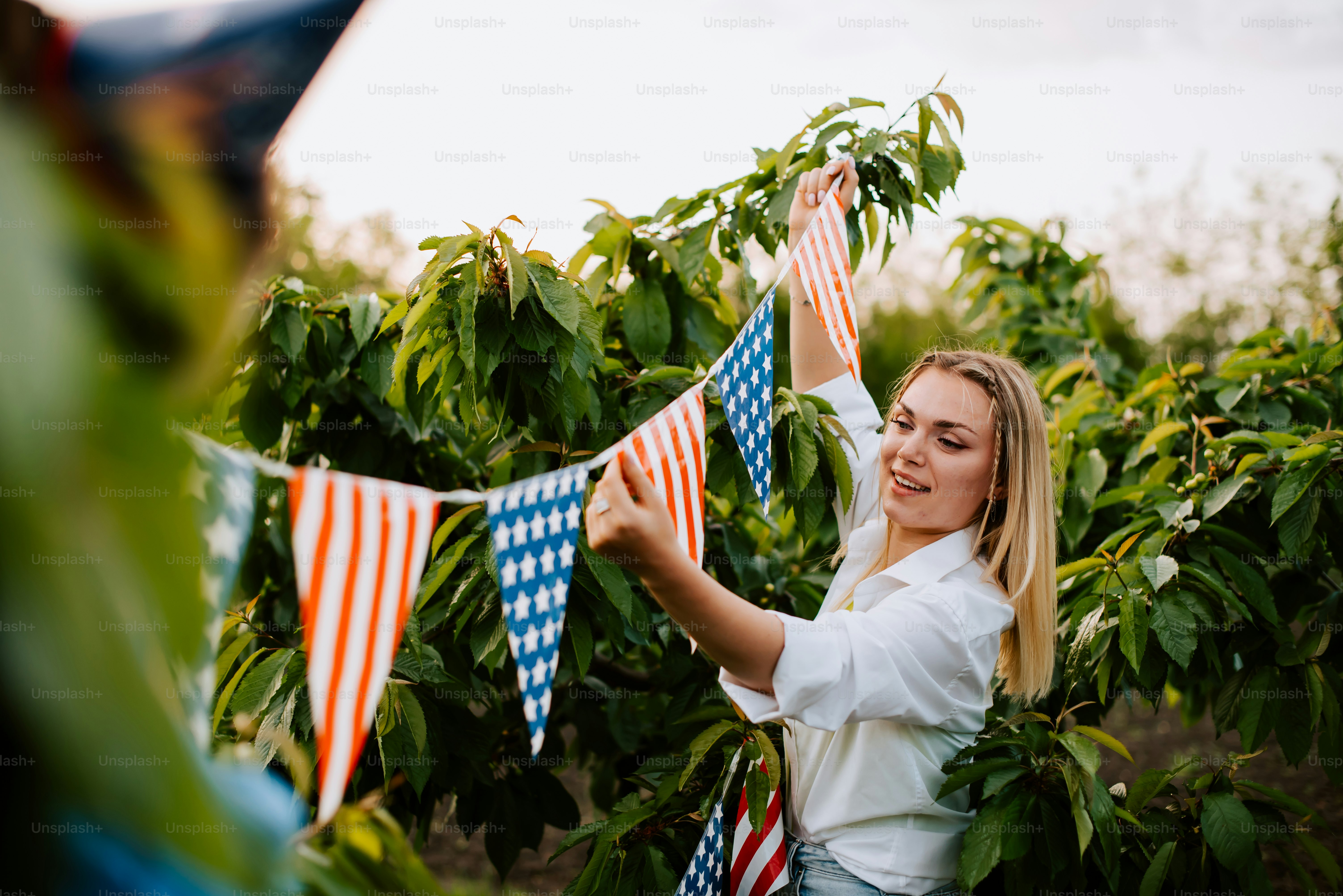 A group of people holding american flags and streamers photo – American ...