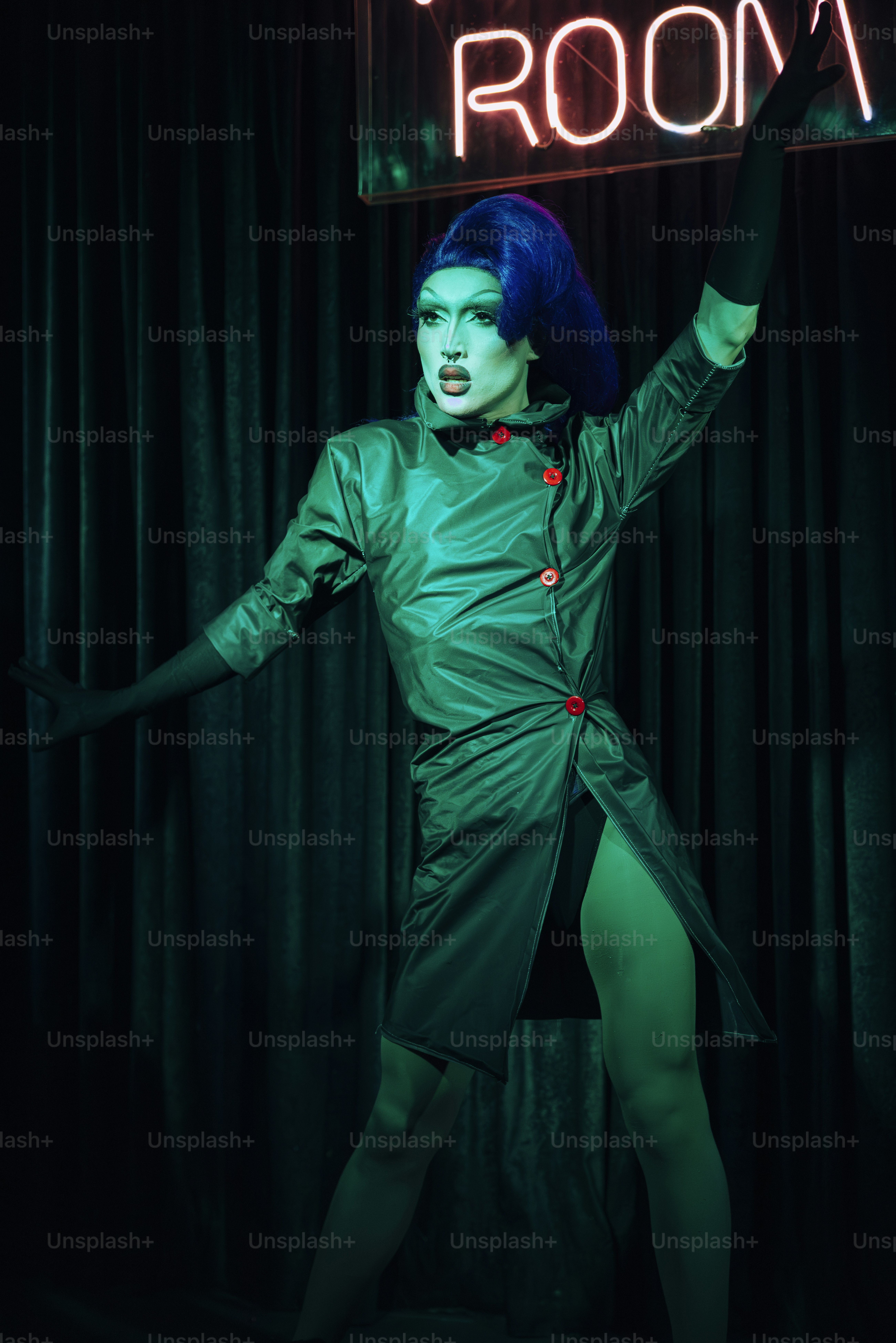 Foto Una mujer con un vestido verde sosteniendo un letrero de neón ...