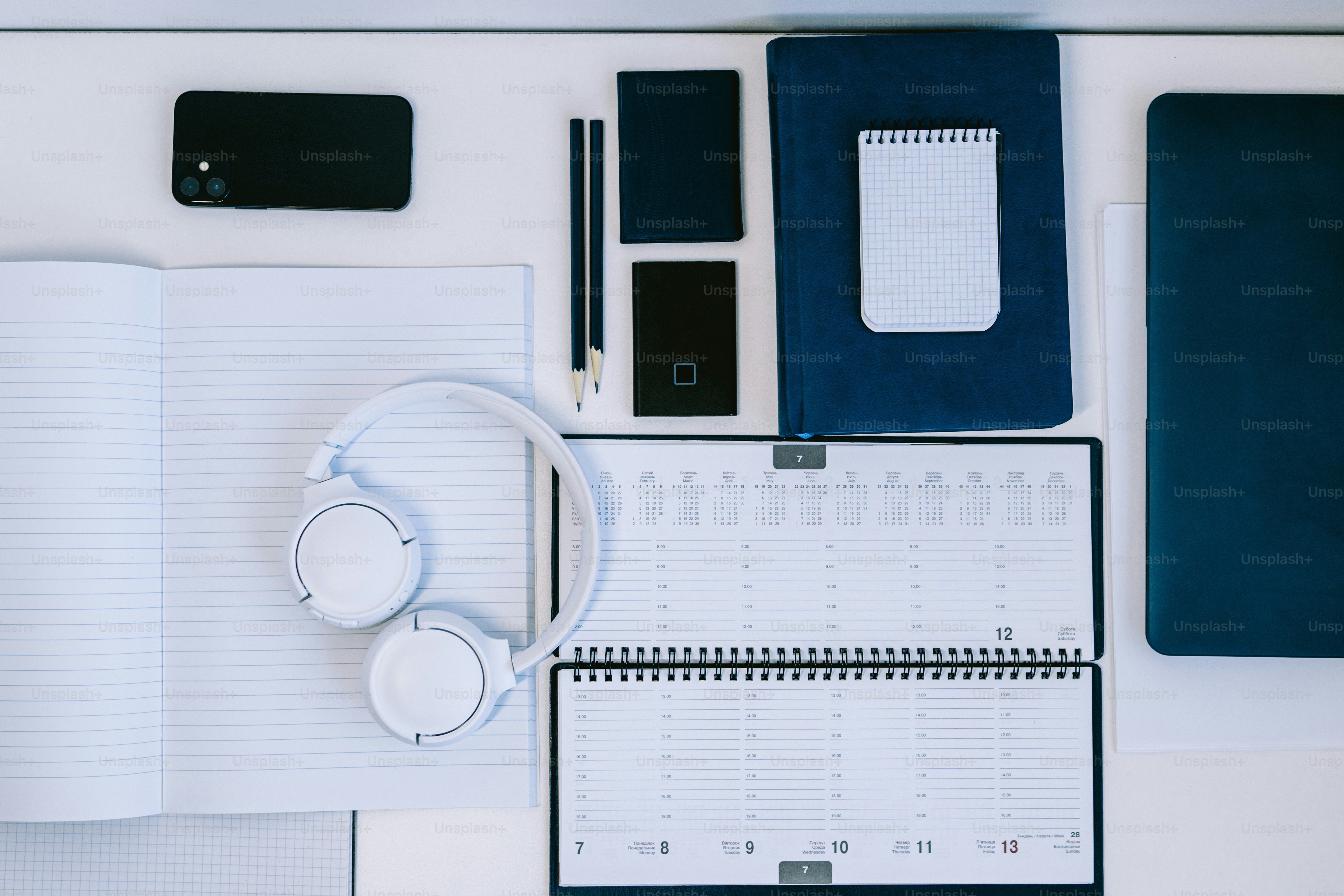 Uma mesa com bloco de notas, caneta, caderno e lápis foto – Imagem ...