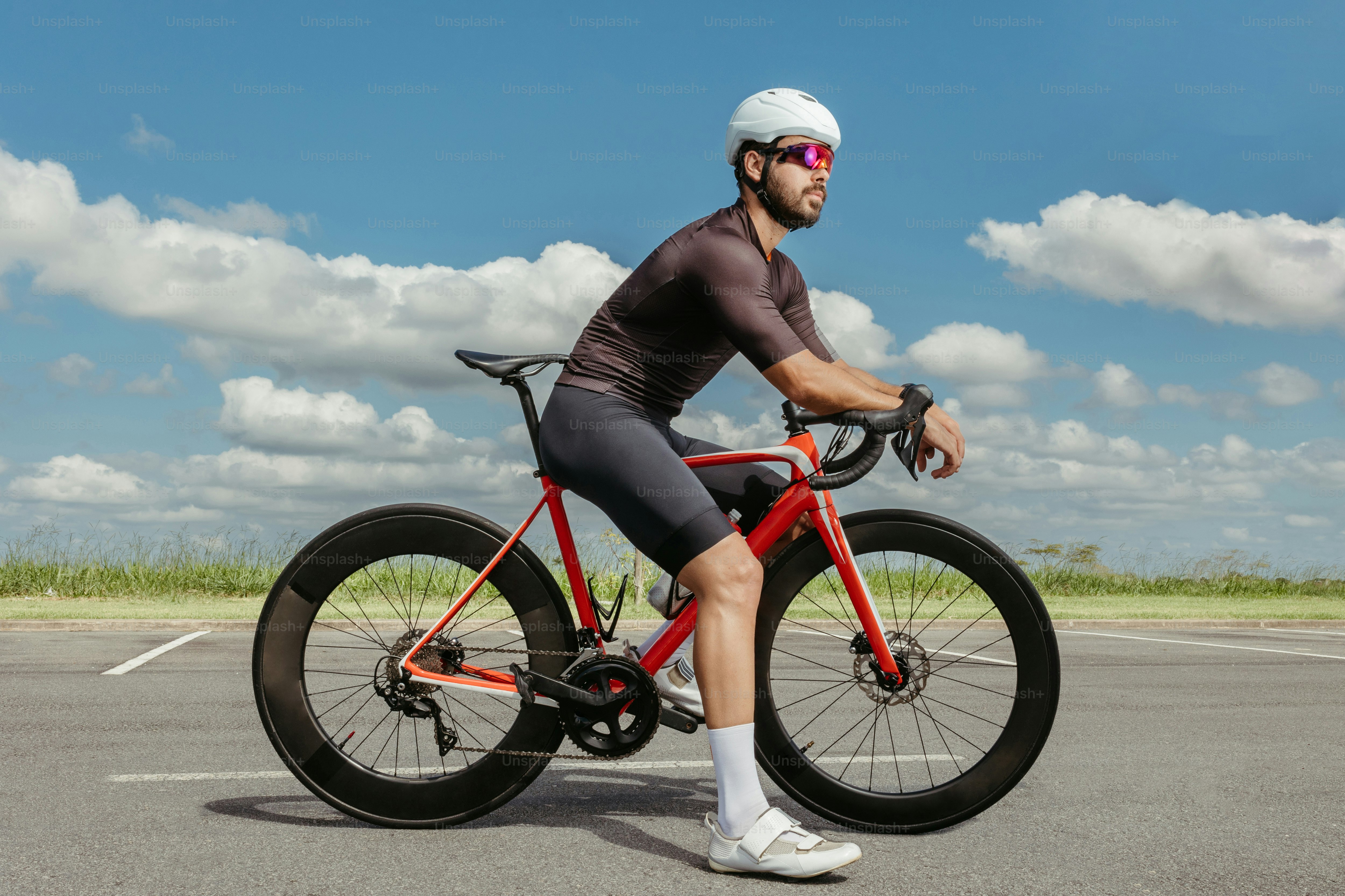 A man riding a bike on top of a parking lot photo – Cycling Image on ...