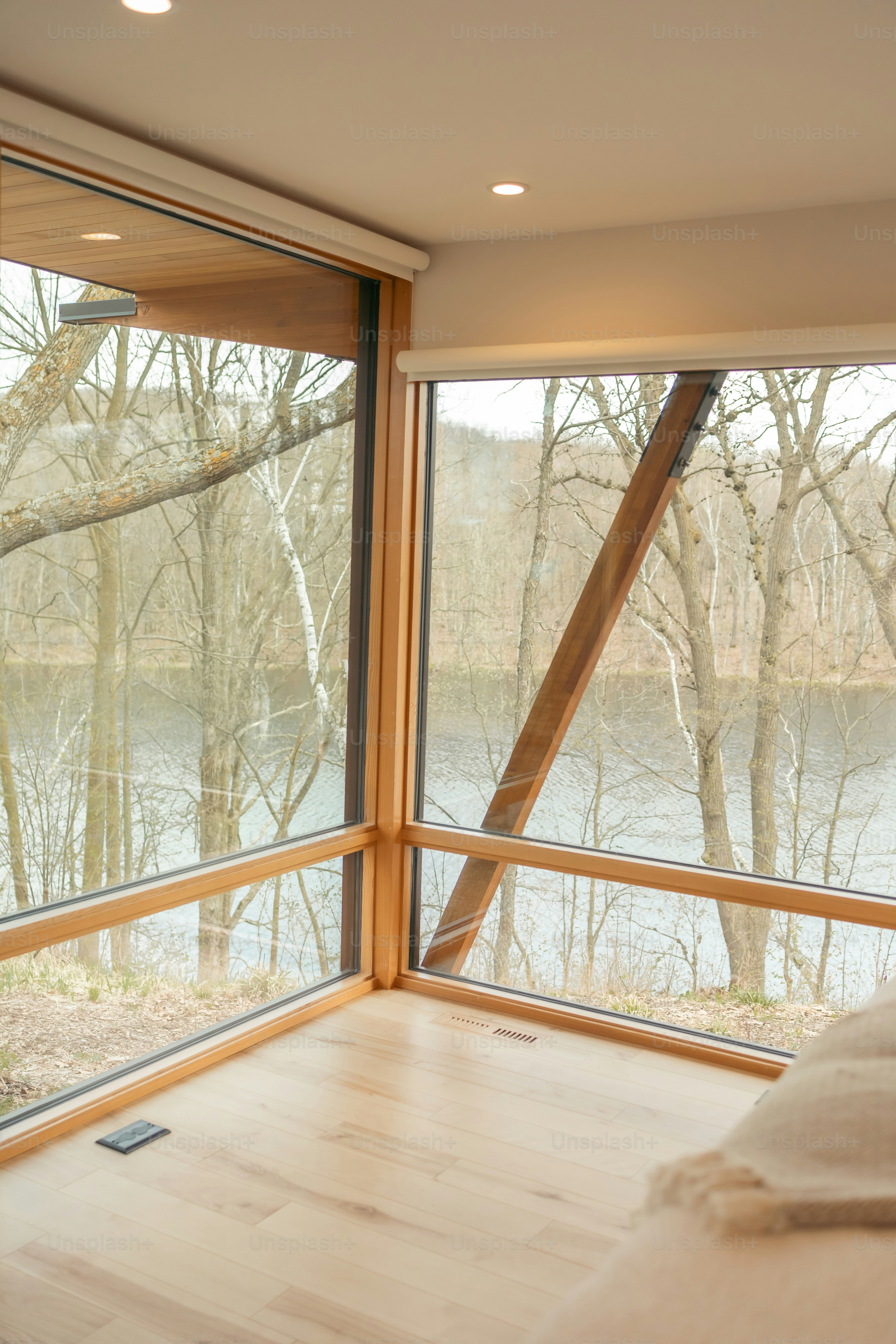 A bedroom with a large window overlooking a lake photo – Airbnb Image ...