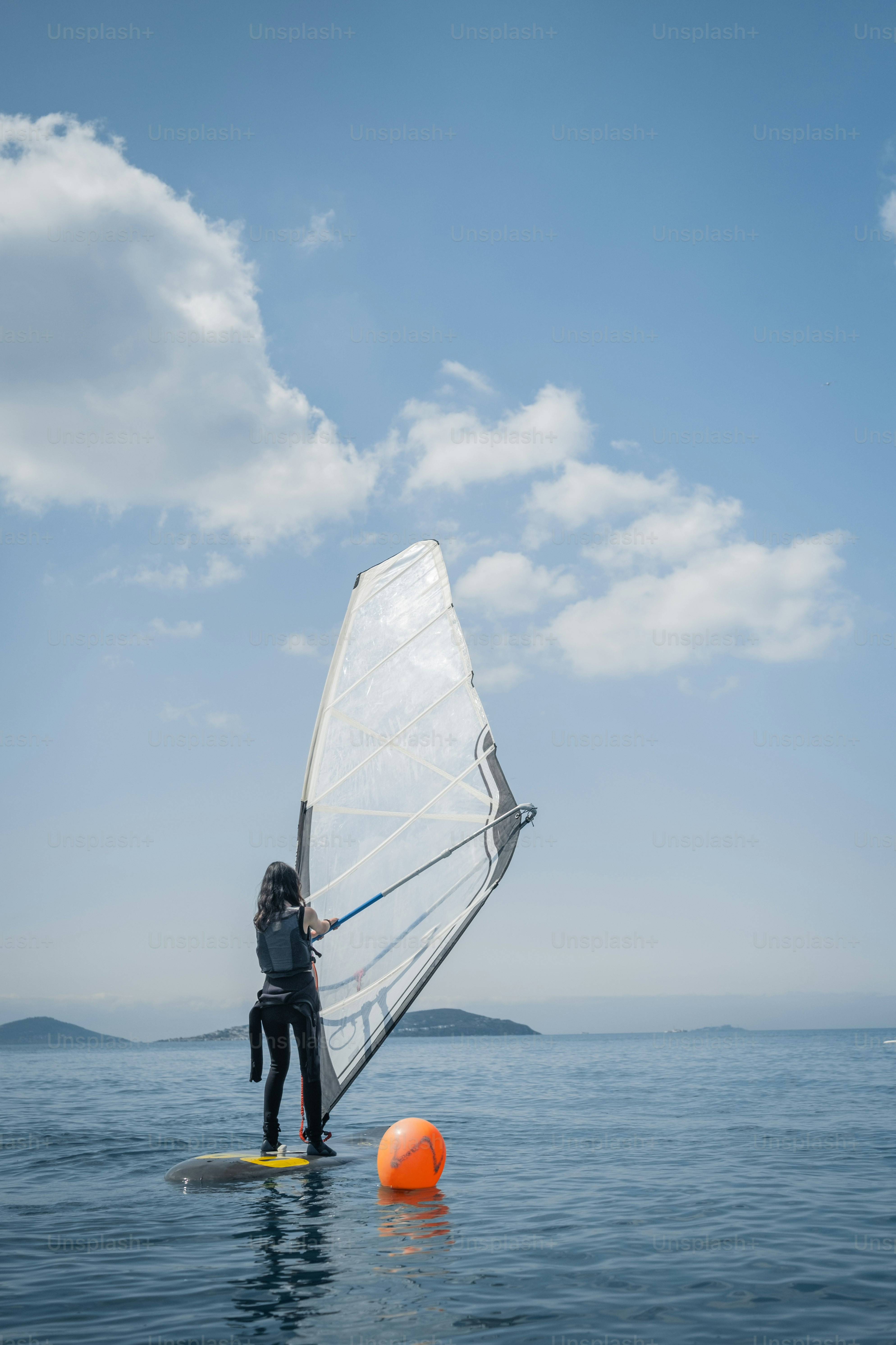 A person on a surfboard with a sail photo – Windsurfing Image on Unsplash
