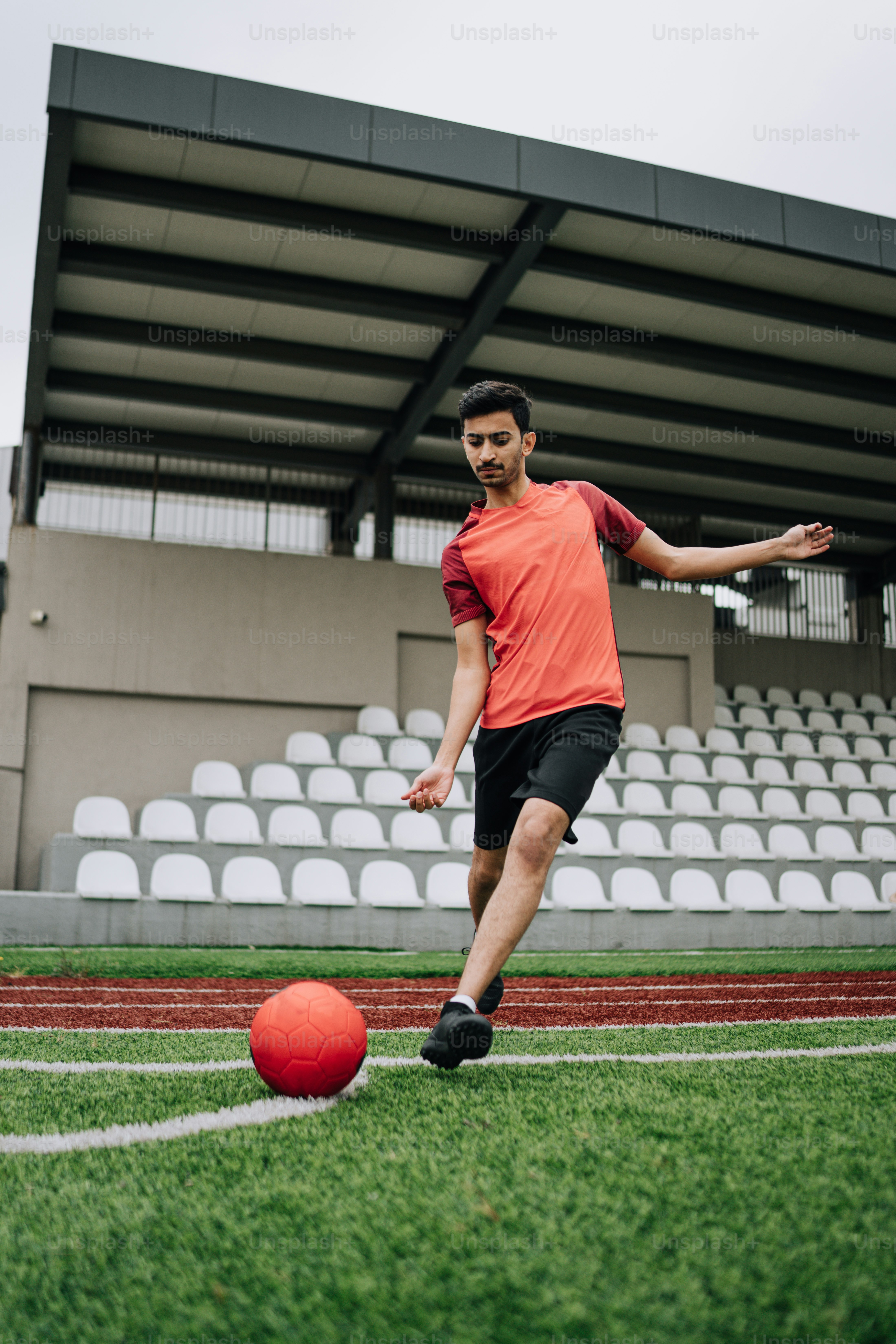 A man kicking a soccer ball on a field photo – Soccer Image on Unsplash
