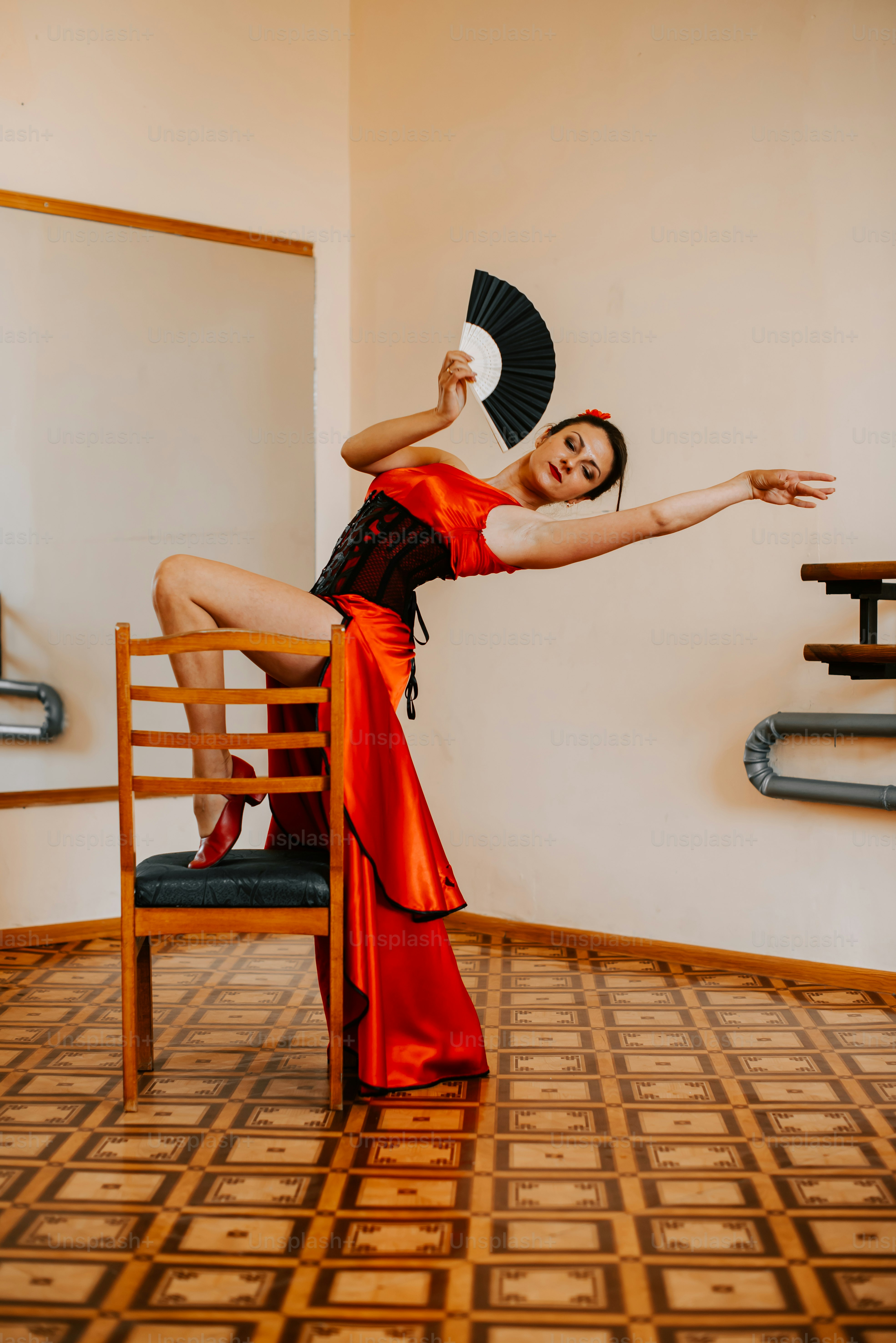 A woman in a red dress is dancing on a chair photo – Flamenco dancer ...